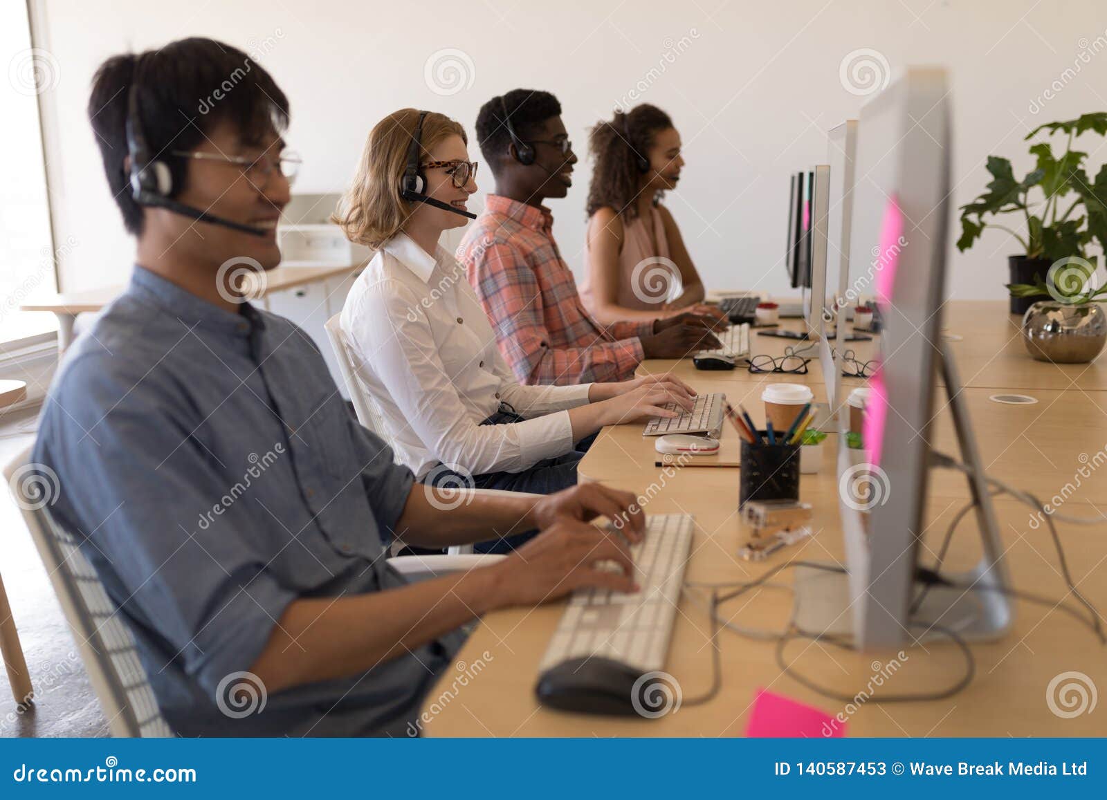 Executives Working on Personal Computer while Talking on Headset in ...
