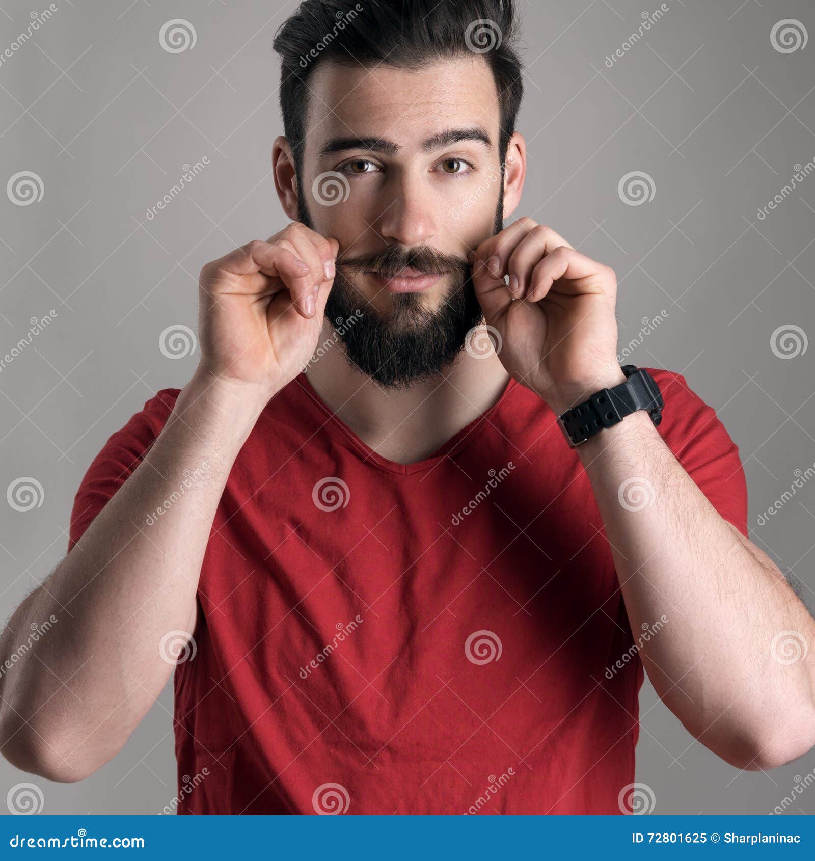Portrait of Young Expressive Hipster Adjusting Mustache with Fingers ...