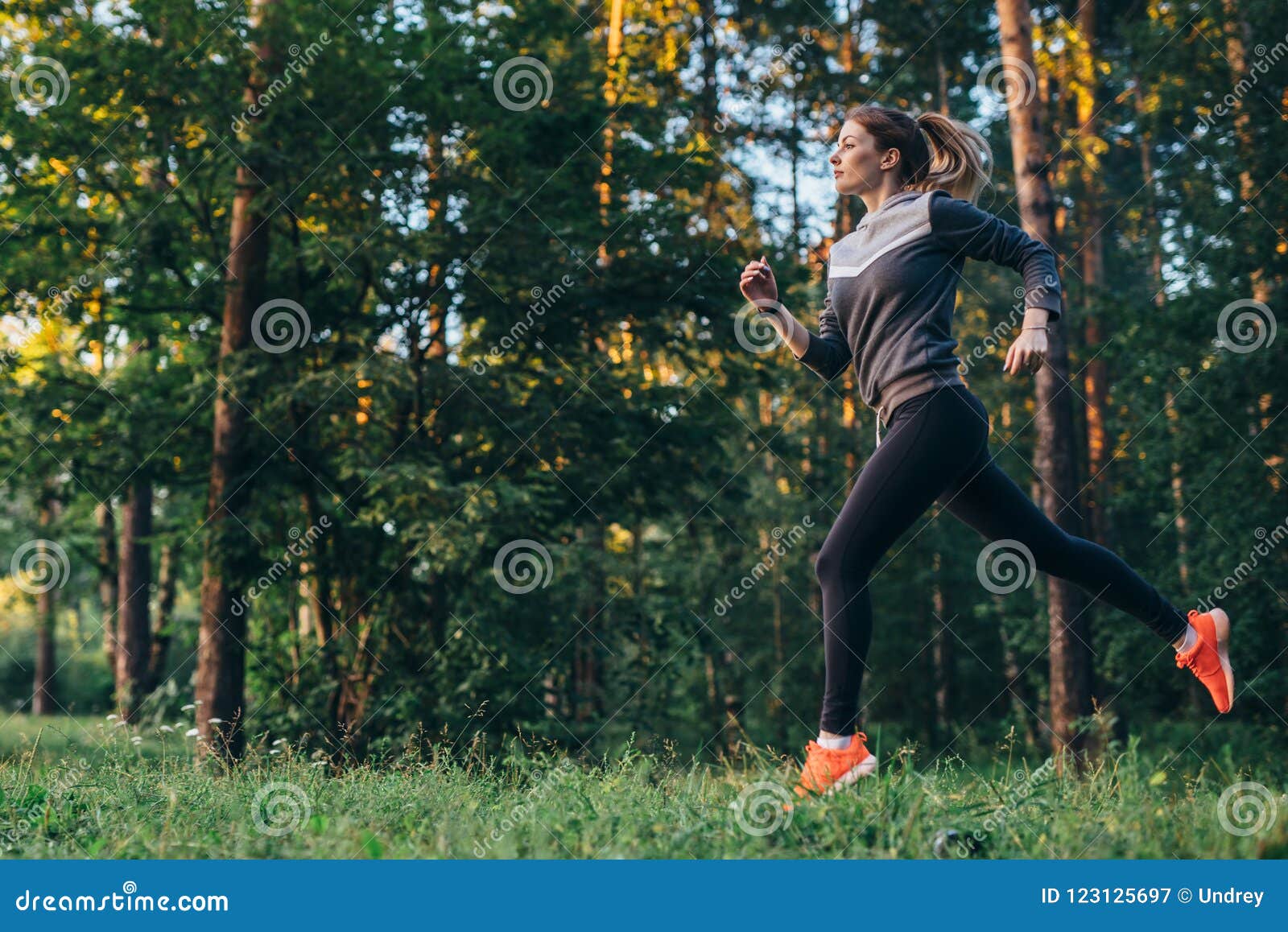 Portrait of Young Female Athlete Wearing Tracksuit Running in Forest ... Portrait of Young Female Athlete Wearing Tracksuit Running in Forest ...