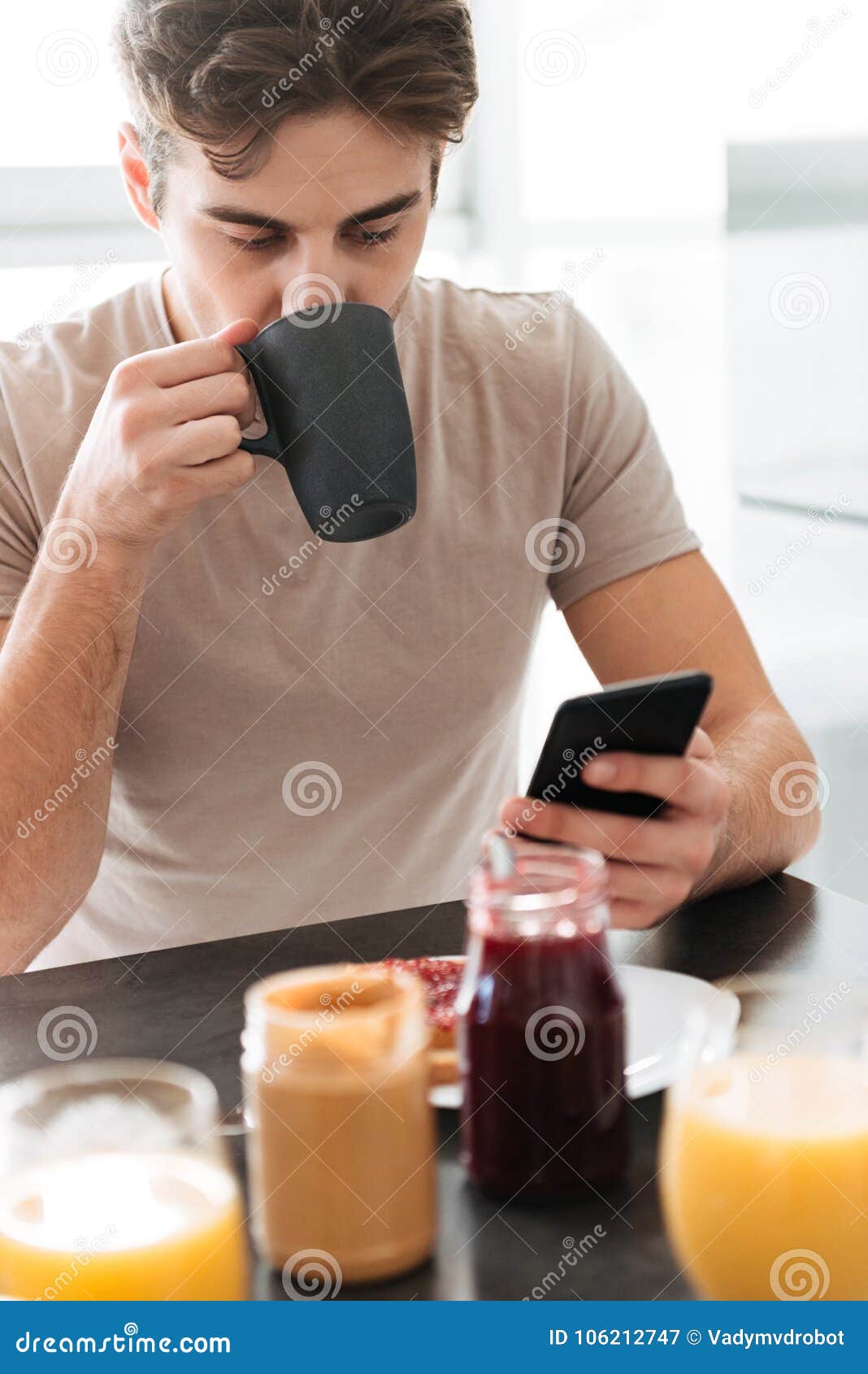 Portrait of Young Focused Man Drinking Tea and Using Smartphone Stock ...