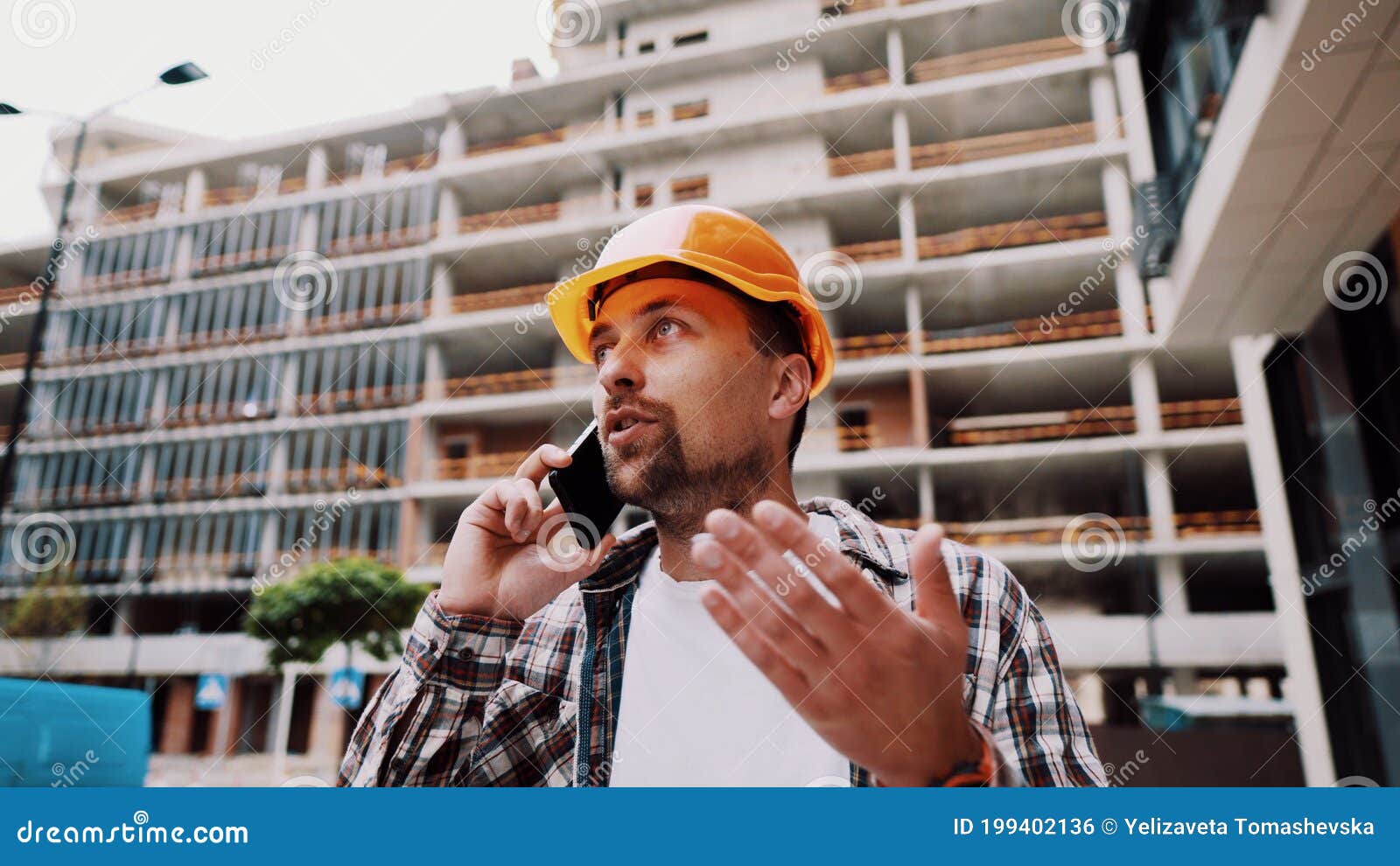Portrait of Young Handyman Making Call while Standing at Construction ...