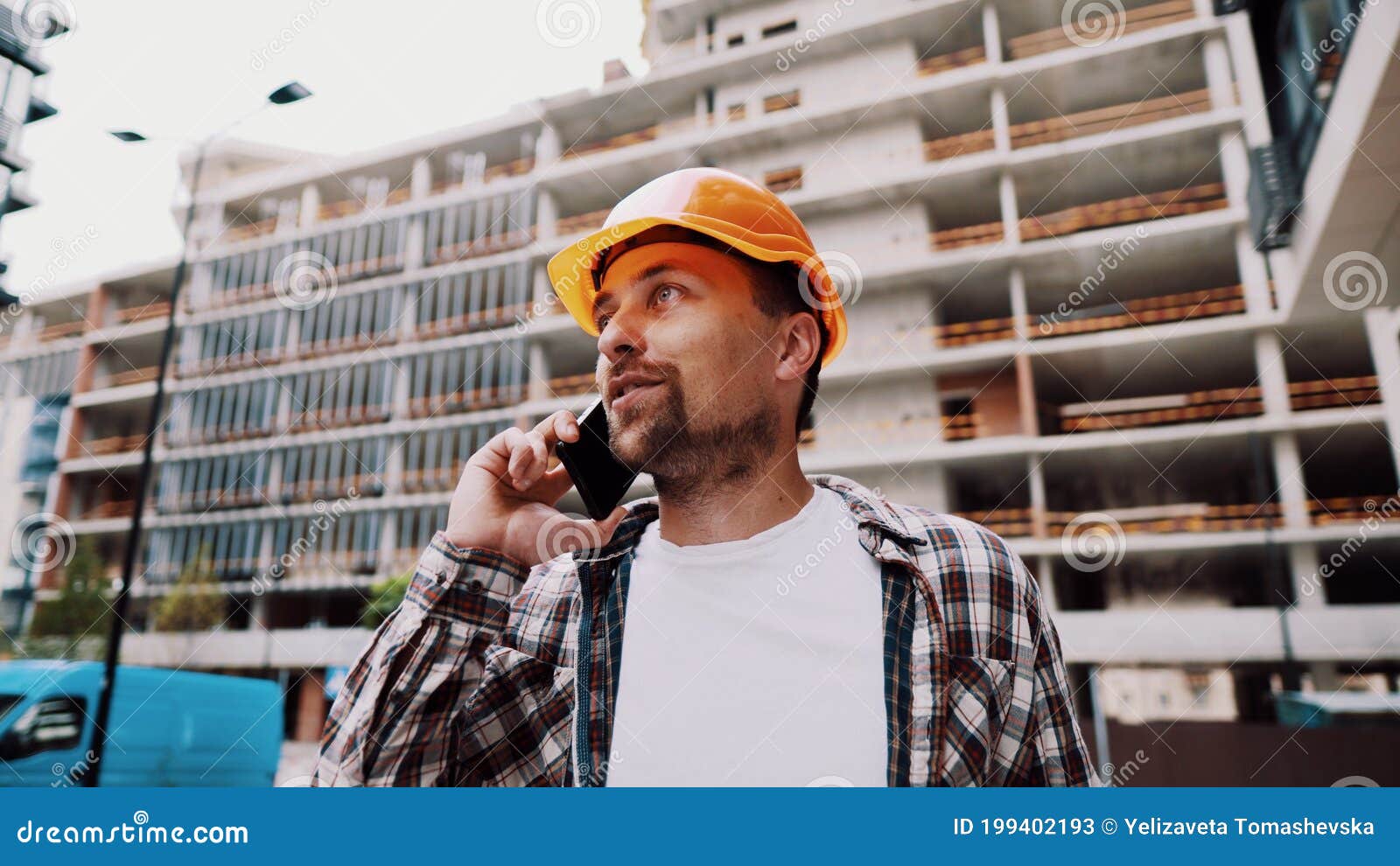 Portrait of Young Handyman Making Call while Standing at Construction ...