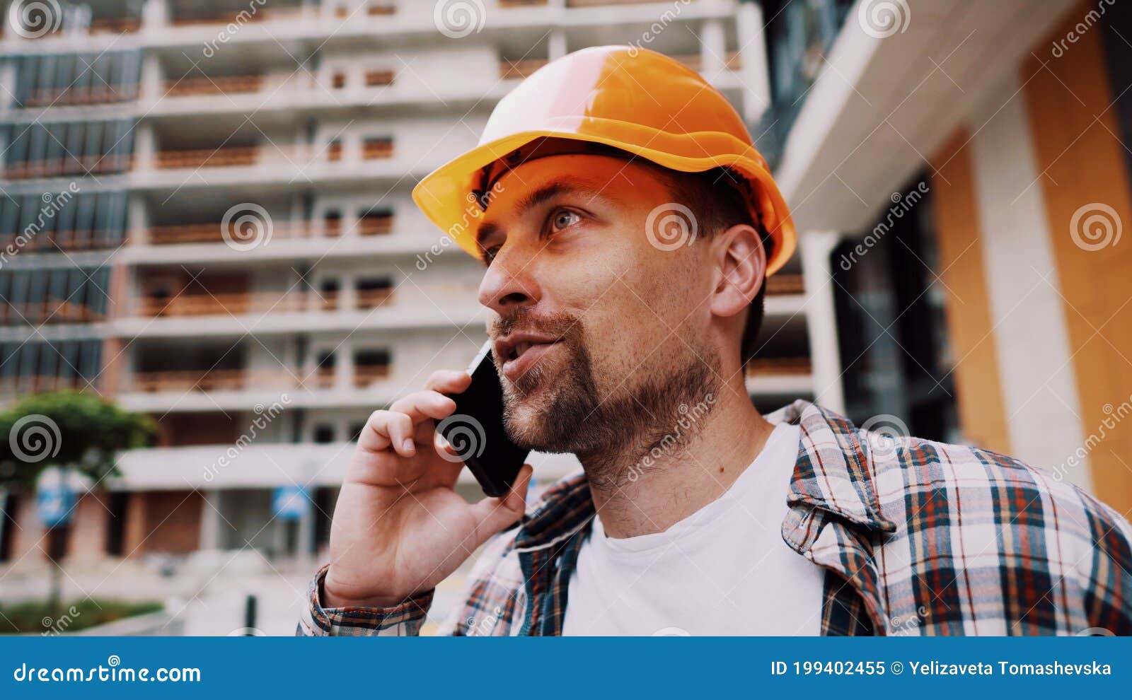 Portrait of Young Handyman Making Call while Standing at Construction ...