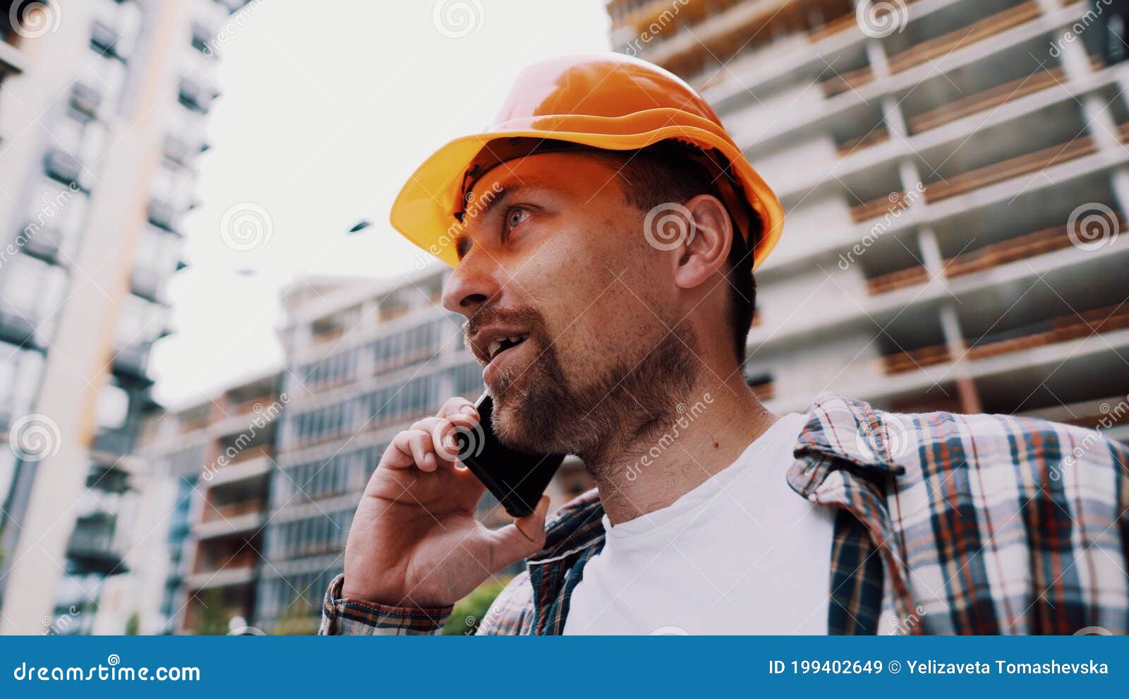 Portrait of Young Handyman Making Call while Standing at Construction ...