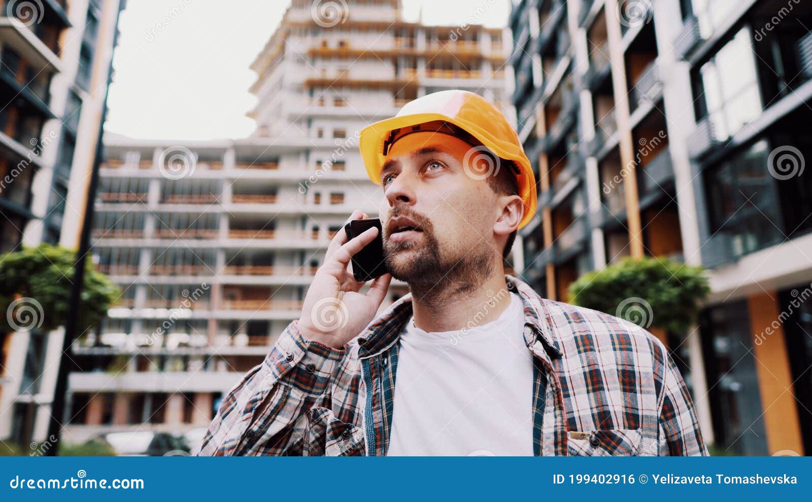 Portrait of Young Handyman Making Call while Standing at Construction ...