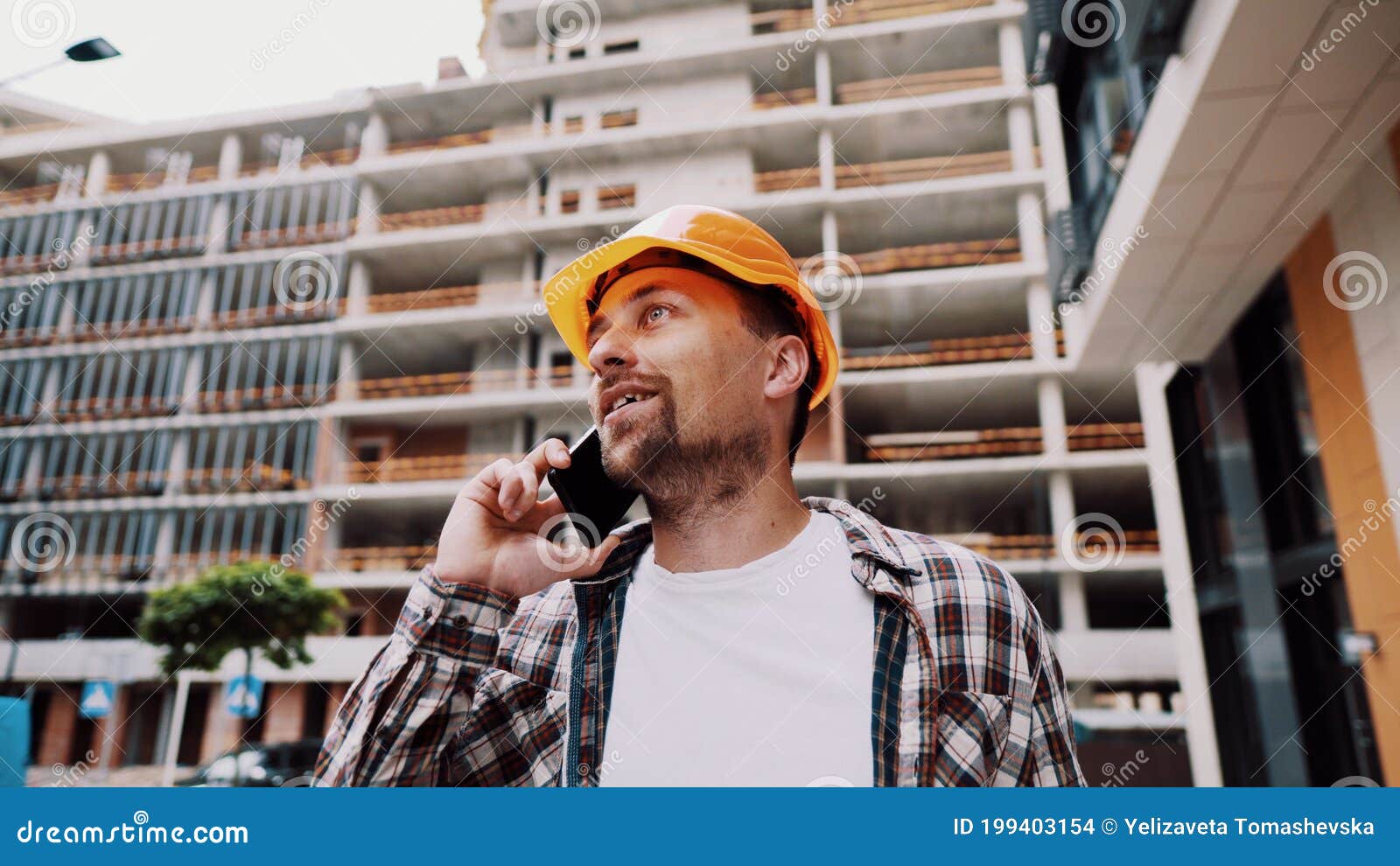 Portrait of Young Handyman Making Call while Standing at Construction ...