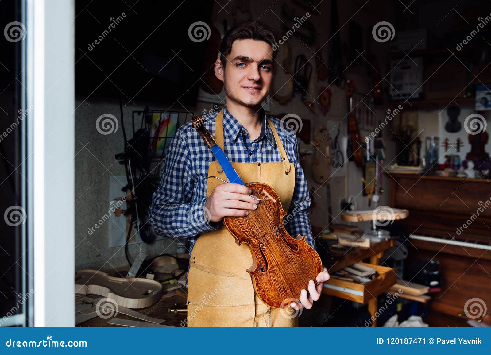 Portrait of a Young Luthier with a Handcrafted Violin in His Workshop ...