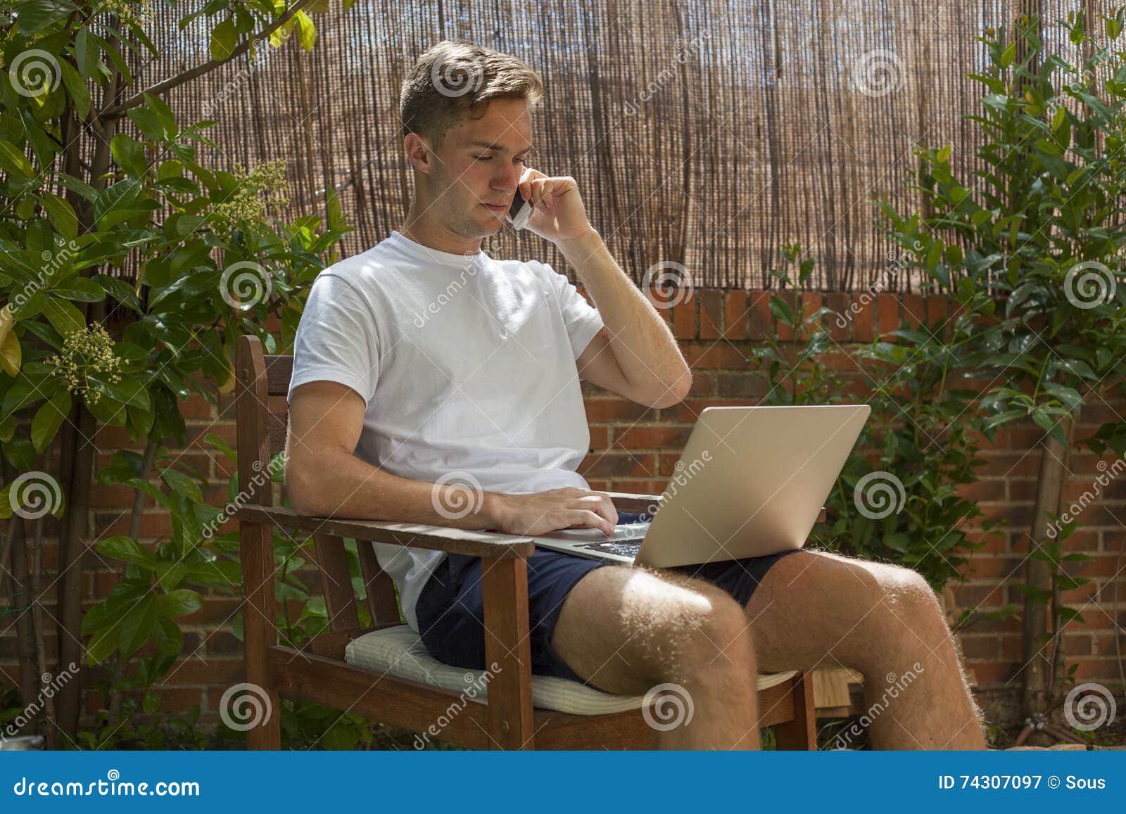 Portrait of Young Man with a Computer and Talking on the Phone Stock ...