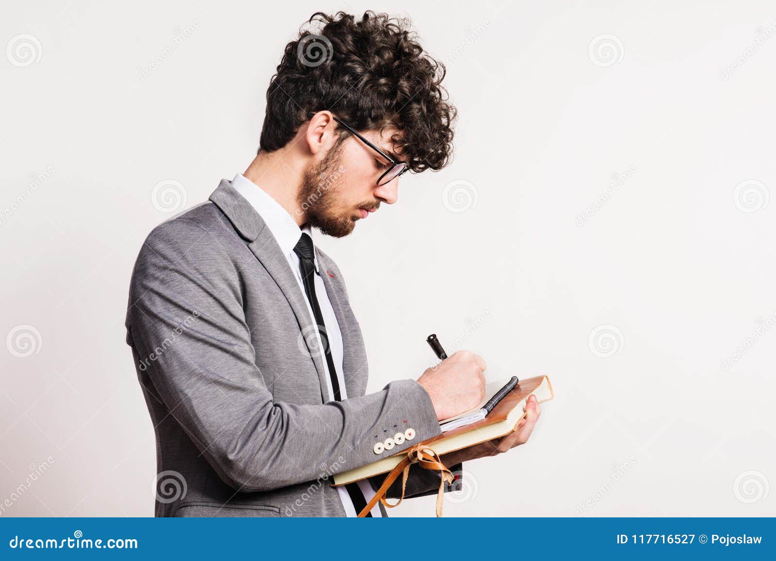 Portrait of a Young Man with a Notepad in a Studio on a White ...