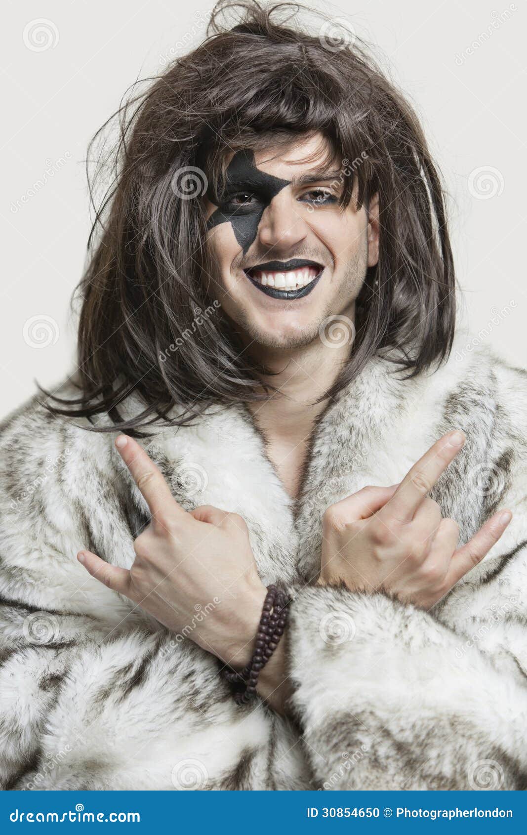 Portrait of Young Man with Painted Face Making Rebellious Gestures Over ...