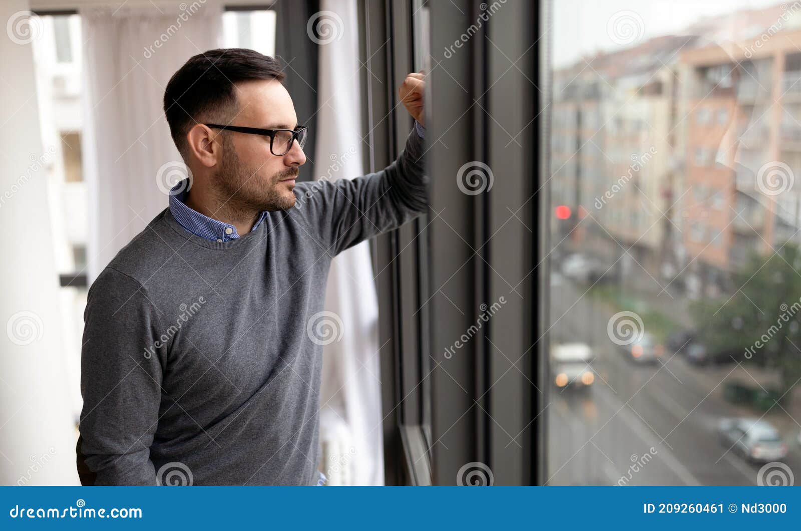 Portrait of Man Sad and Depressed Standing at Window in Despair at Home ...