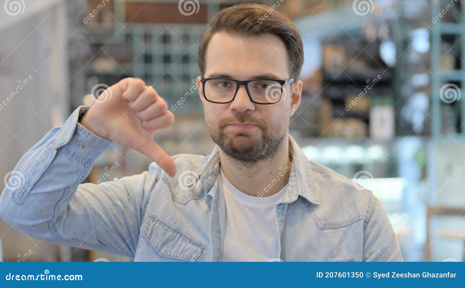 Portrait of Young Man Showing Thumbs Down Sign Stock Photo - Image of ...