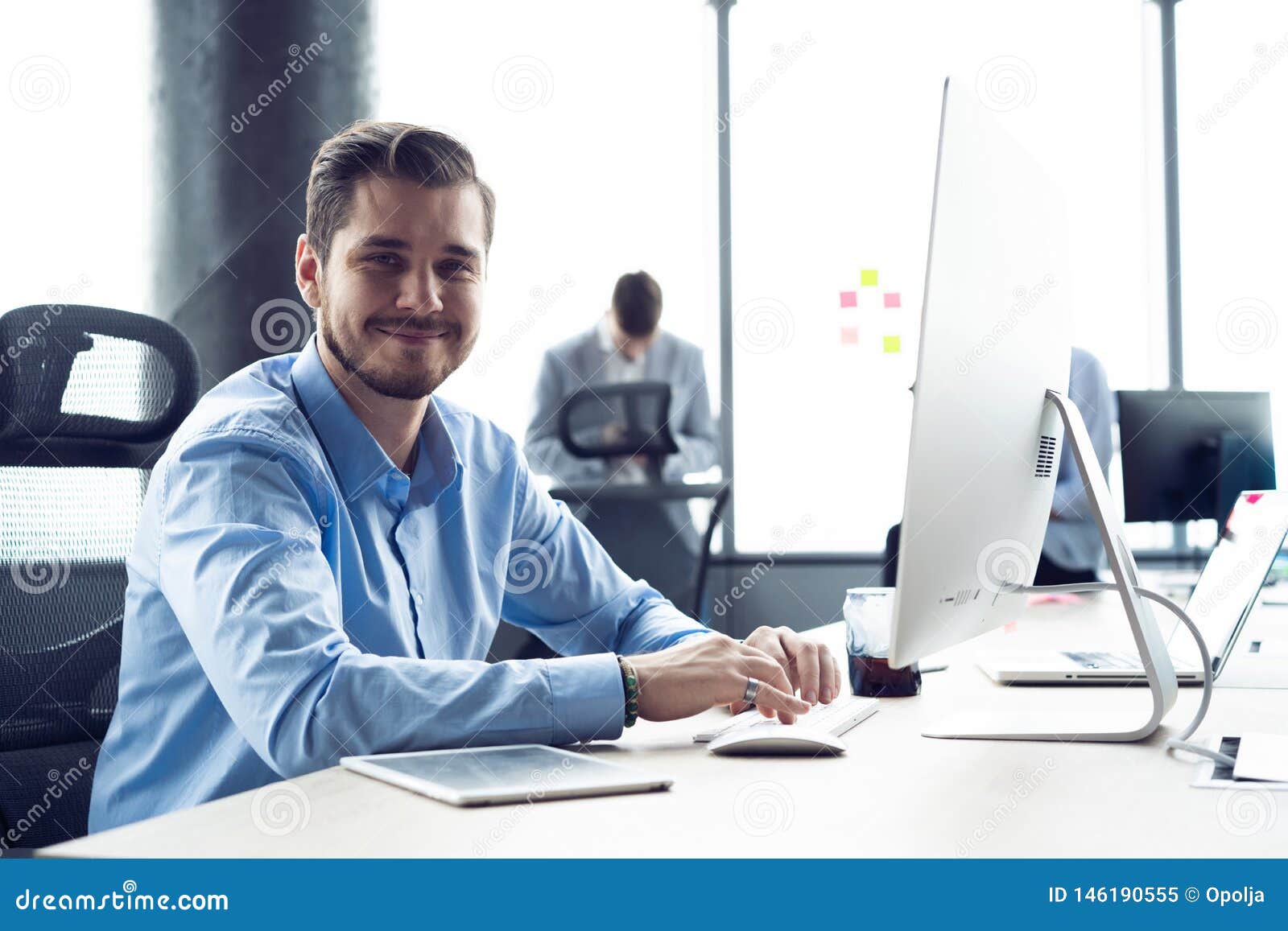 Portrait of Young Man Sitting at His Desk in the Office. Stock Image ... Portrait of Young Man Sitting at His Desk in the Office. Stock Image ...