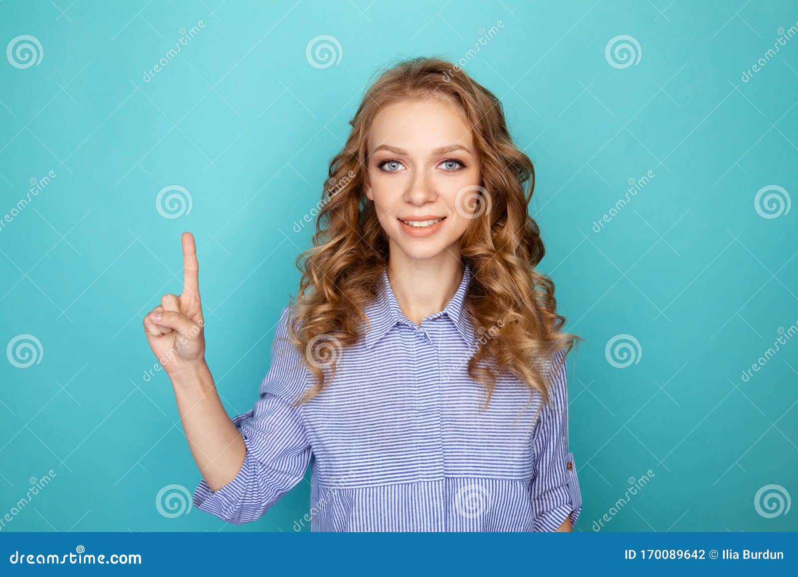 Portrait of Young Model Pointing Up in the Blue Studio. Stock Photo ...