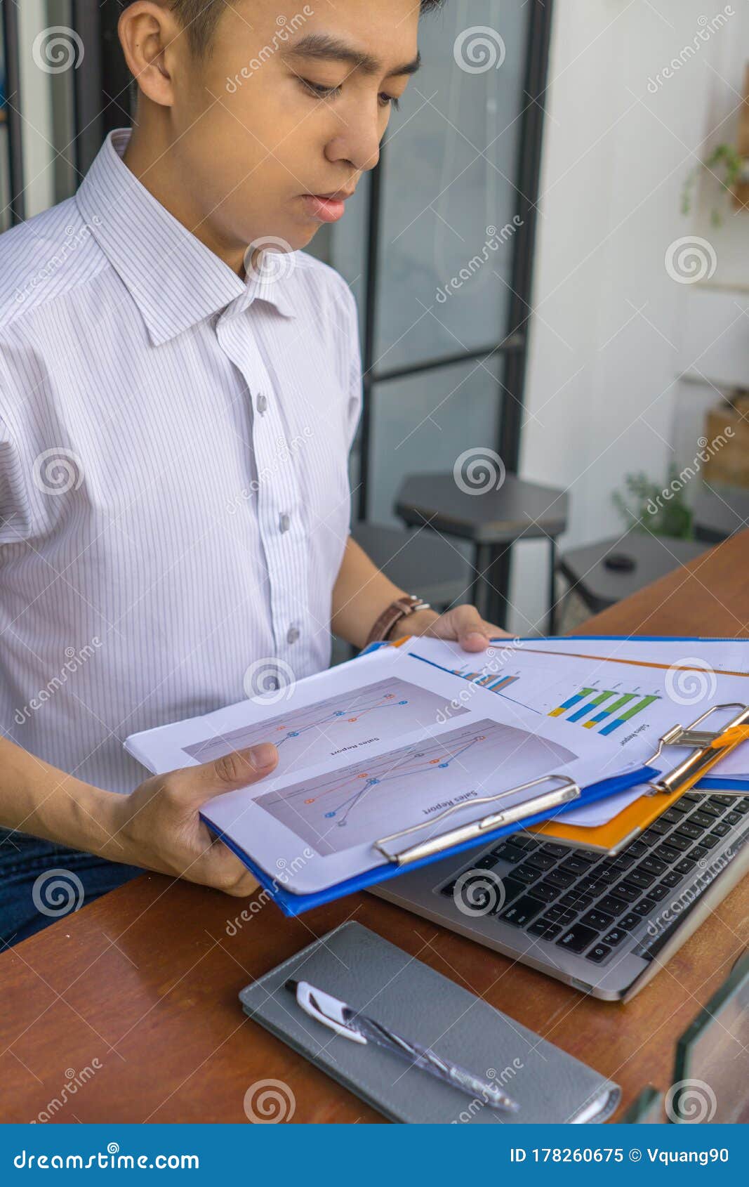 Portrait of Young Office Employee Reading Report and Document Stock ...