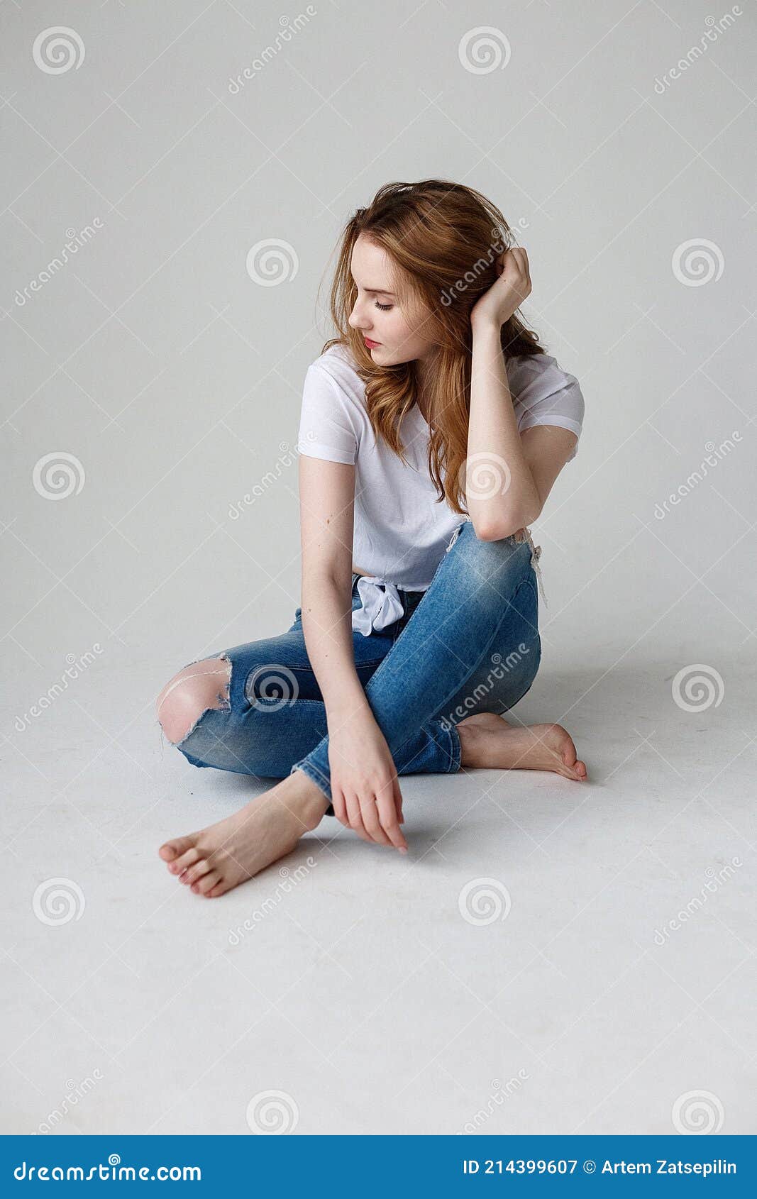 Young Caucasian Woman Posing In T Shirt Ripped Jeans Sitting On