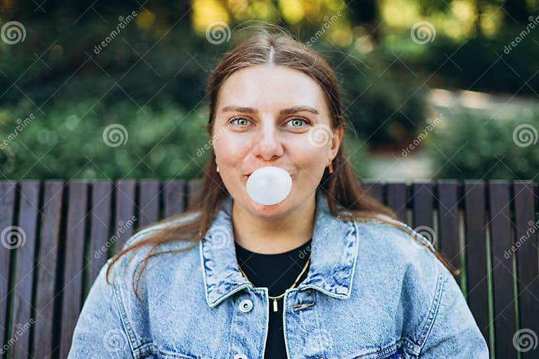 Portrait Of Young Playful Hipster Female In The Park Model Blowing