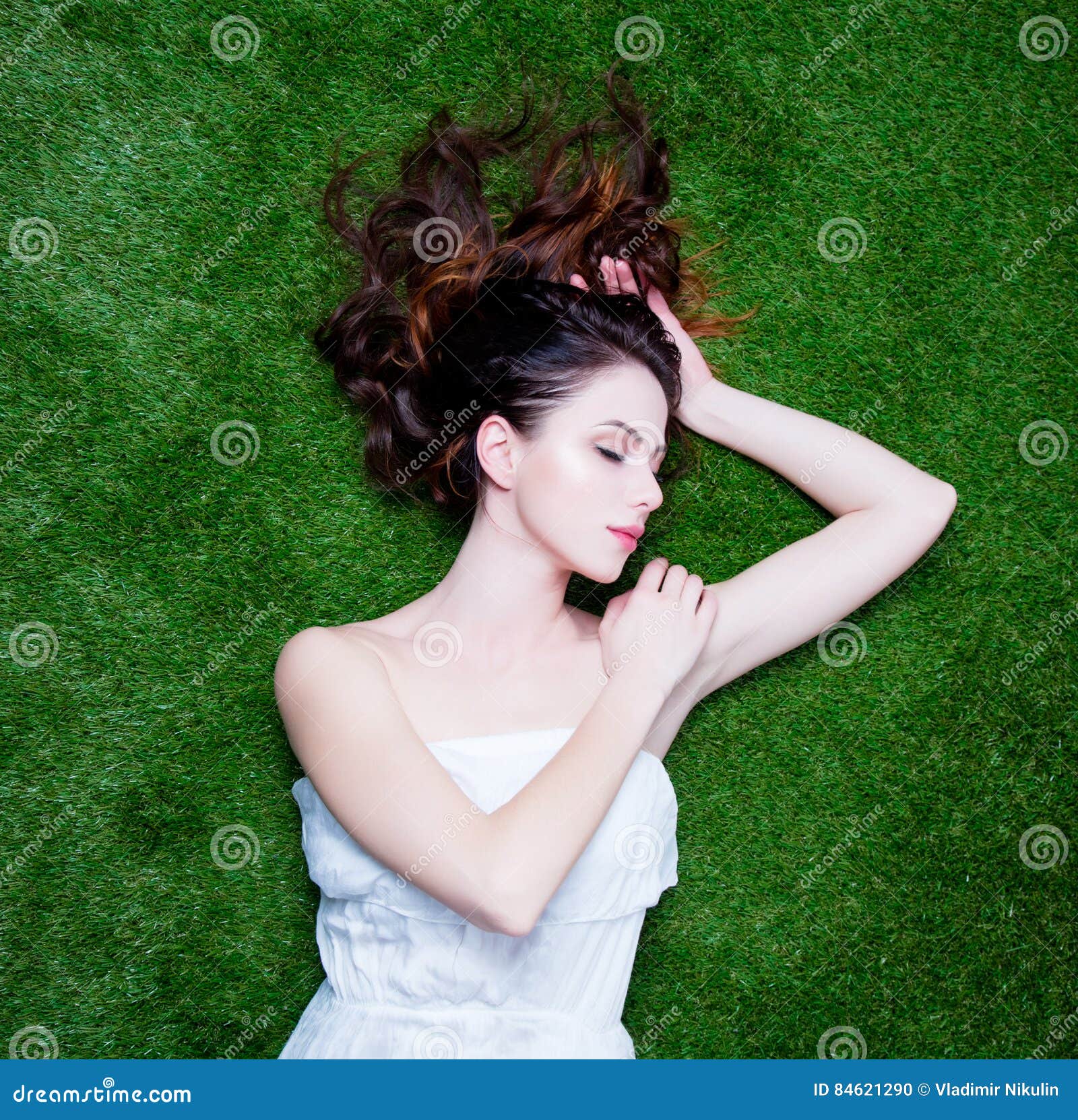 Portrait Of A Young Redhead Woman Lying Down On Green Spring Grass