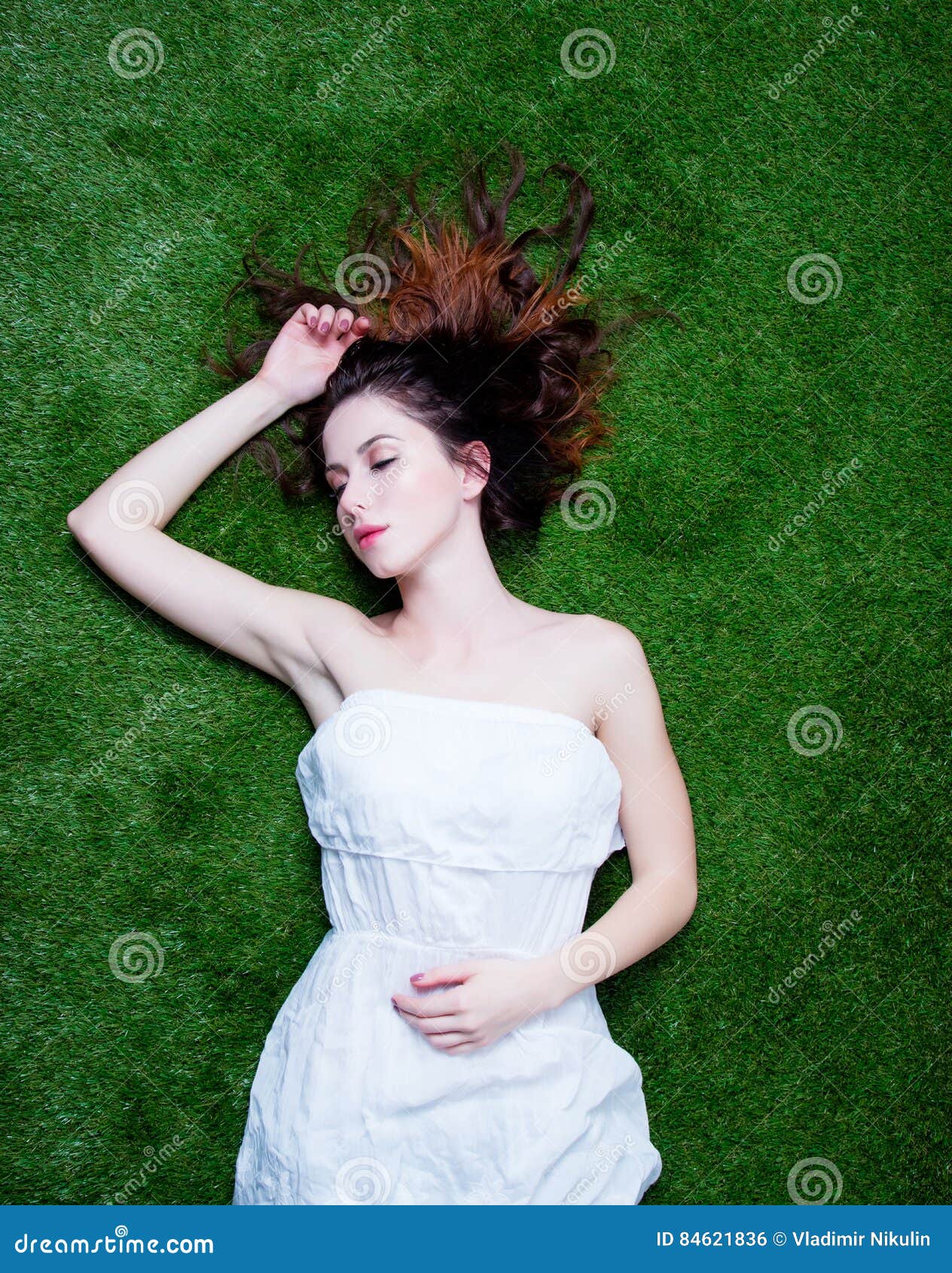 Portrait Of A Young Redhead Woman Lying Down On Green Spring Grass