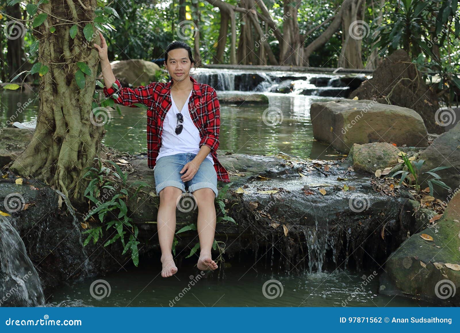 Portrait of a Young Relaxed Man Sitting Near Waterfall Stock Photo ...