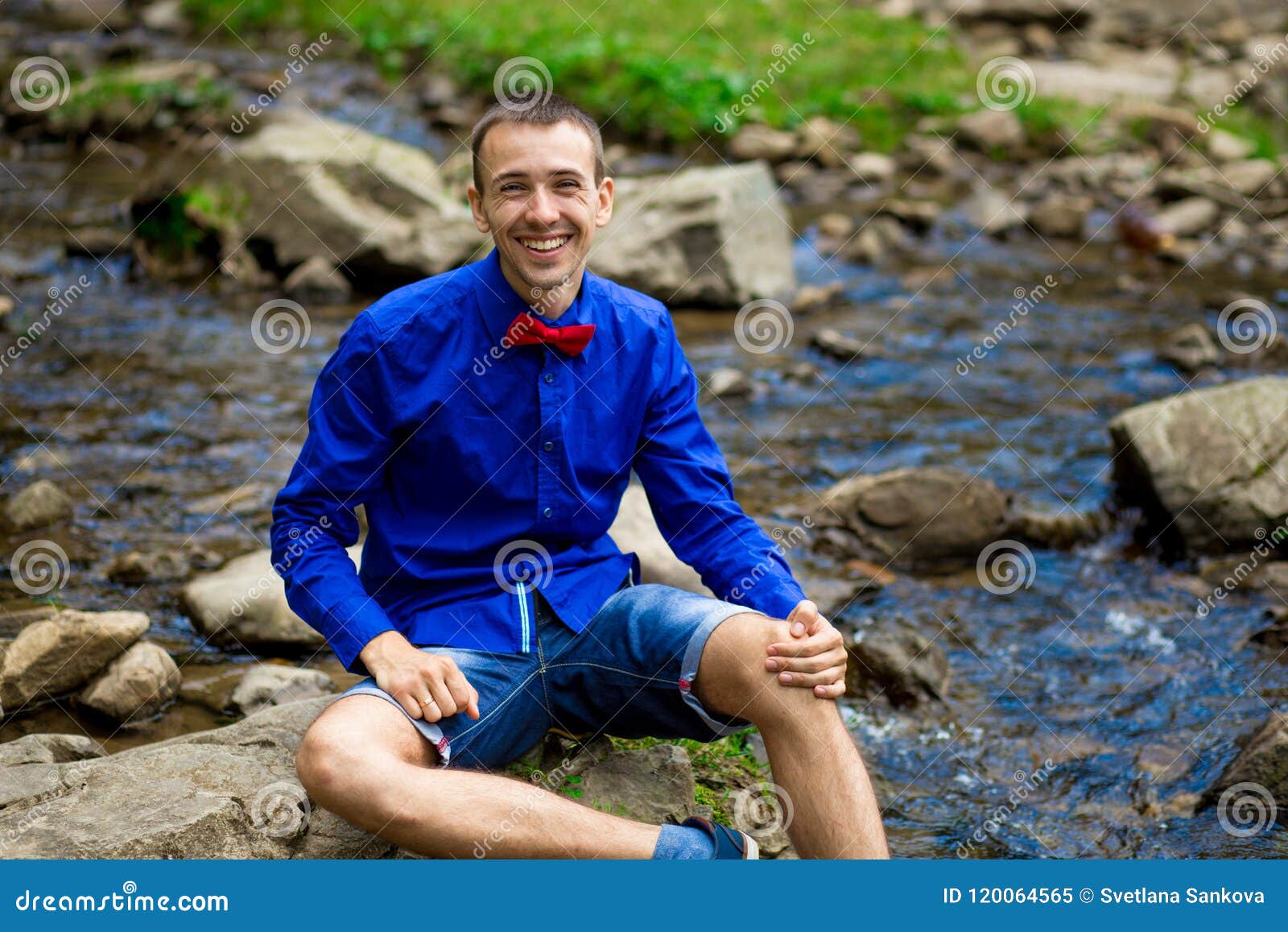 Portrait of Young Smiling Handsome Man in Blue Shirt Near Forest River ... Portrait of Young Smiling Handsome Man in Blue Shirt Near Forest River ...