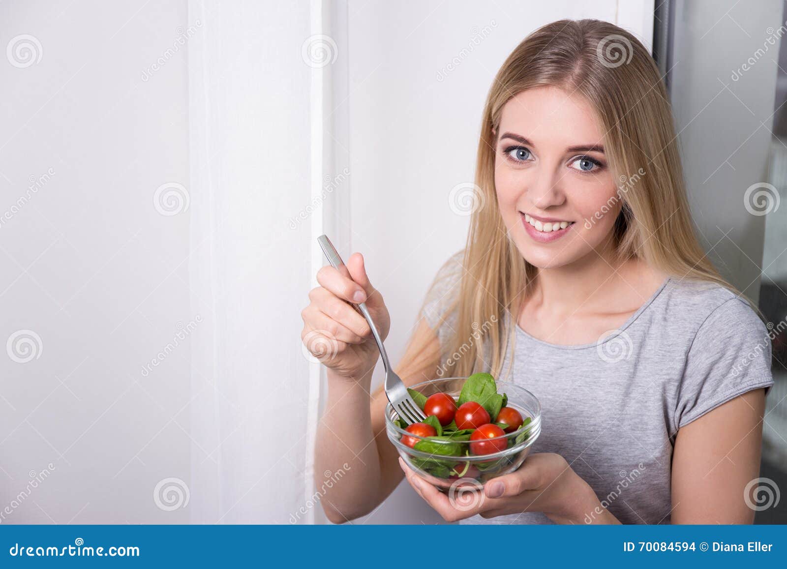 Portrait Of Young Woman Eating Salad With Tomatoes And Spinach Stock
