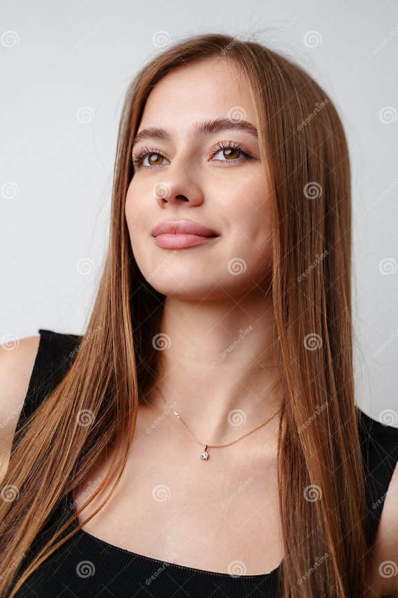 Portrait Of A Young Woman With Long Brown Hair And A Silver Necklace
