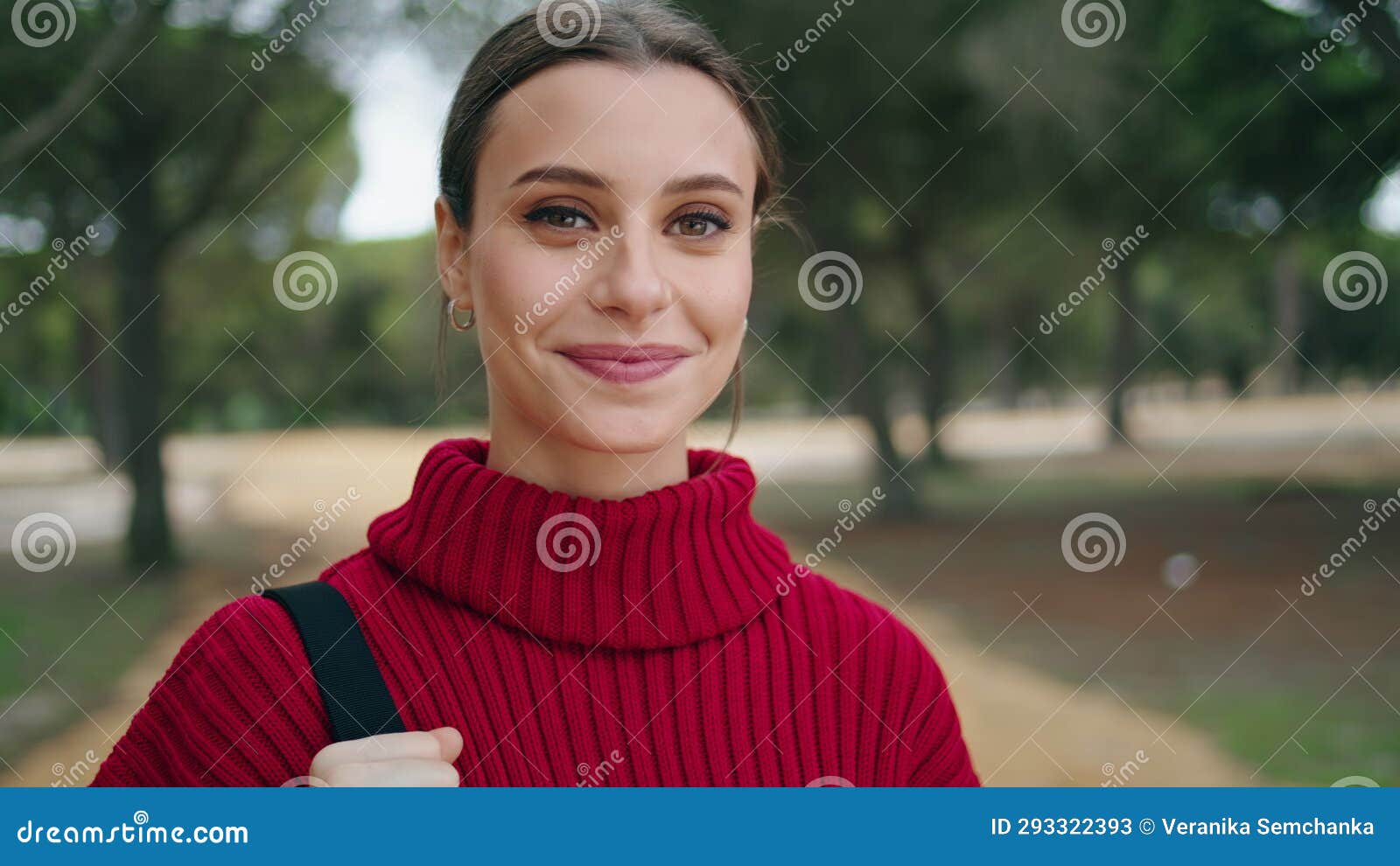 Portrait Young Woman Standing In Front Green Forest Wearing Red Sweater