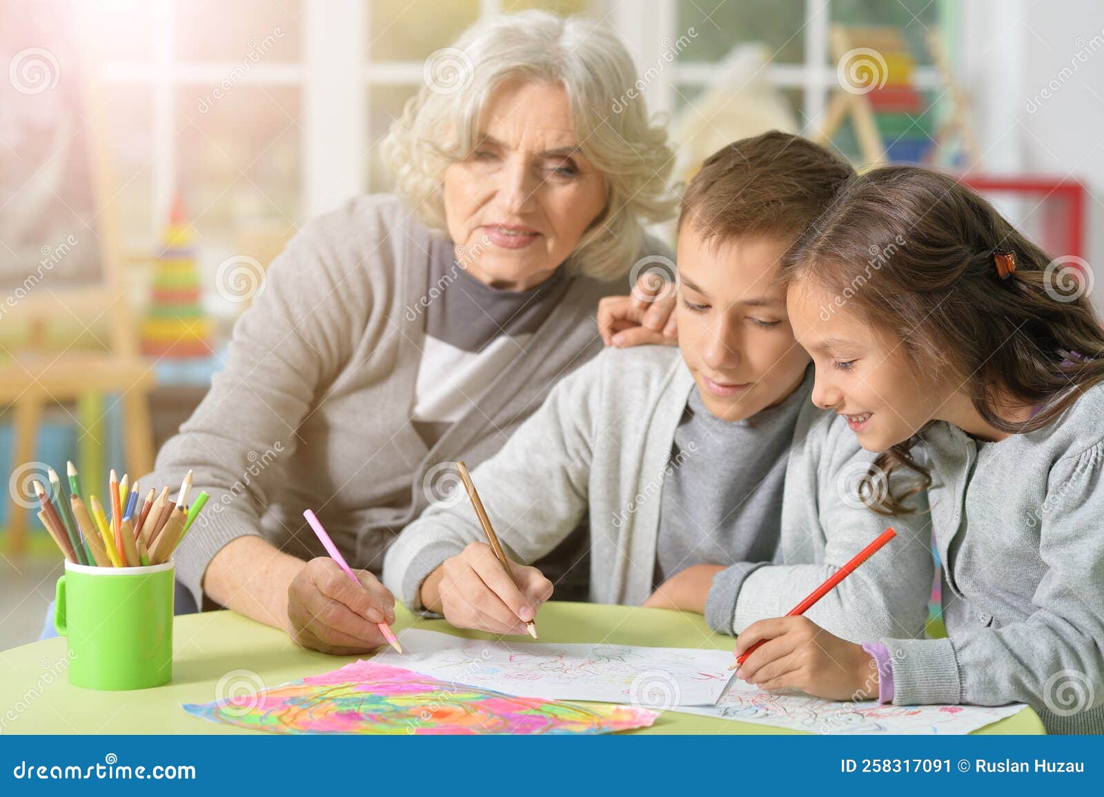 Portret Van Grootmoeder Met Kinderen Die Thuis Tekenen Stock Afbeelding ...