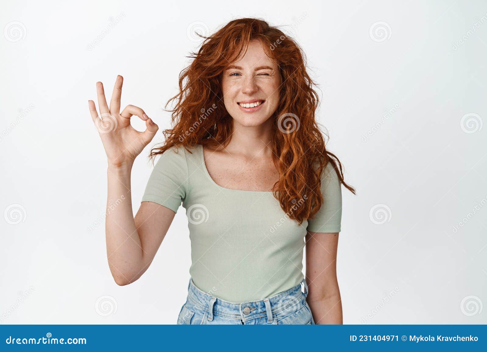 Positive Beautiful Girl With Ginger Hair Winking And Smiling Pleased