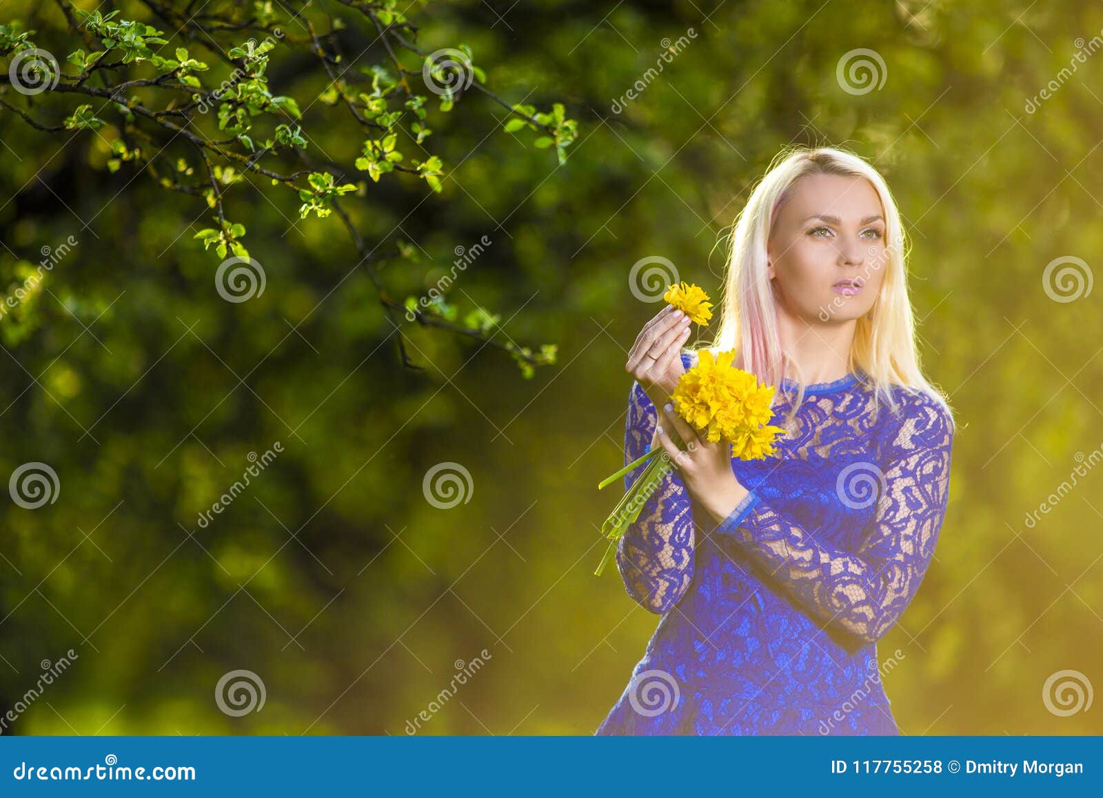 Positive Caucasian Blond With Bunch Of Daffodils Posing In Sunny