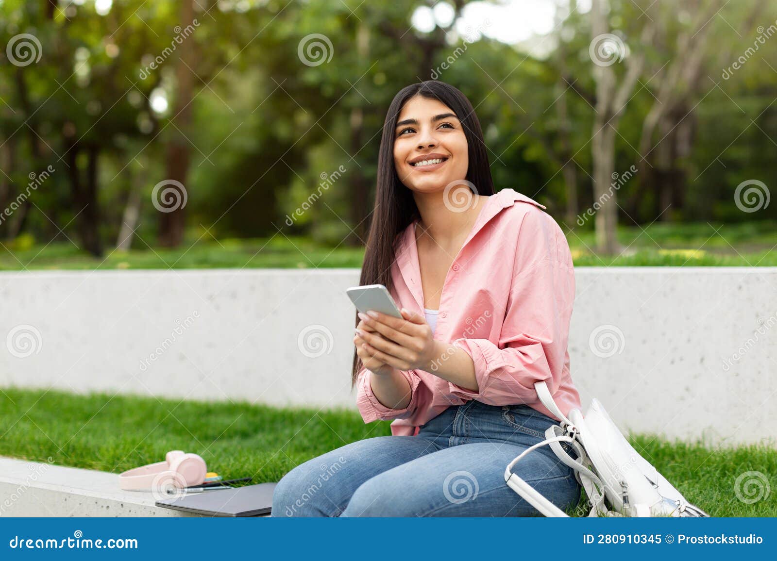 Positive College Lady Using Smartphone Outdoors, Sitting in Park after ...