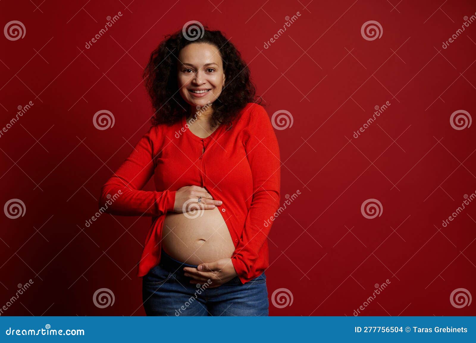 Smiling Positive Pregnant Pretty Woman Caressing Her Belly Looking At