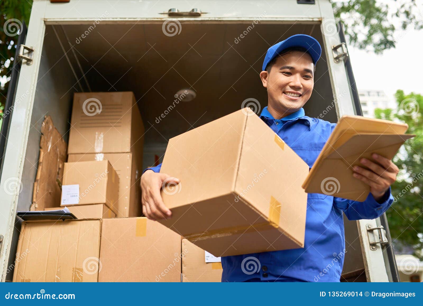 Positive delivery man stock photo. Image of information - 135269014