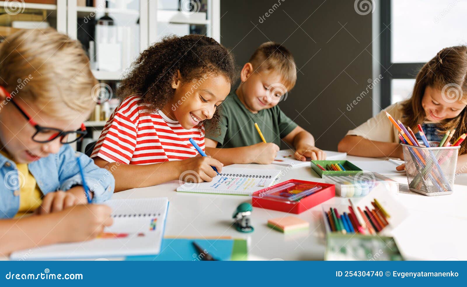 Cheerful Ethnic Girl Solving Test with Classmates Stock Photo - Image ...