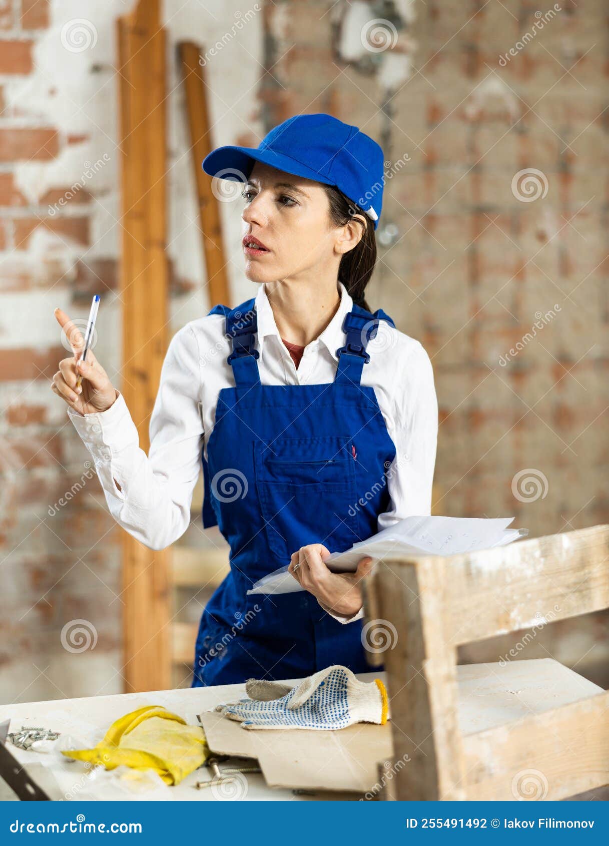 Positive Female Civil Engineer Taking Notes while Checking Indoor ...
