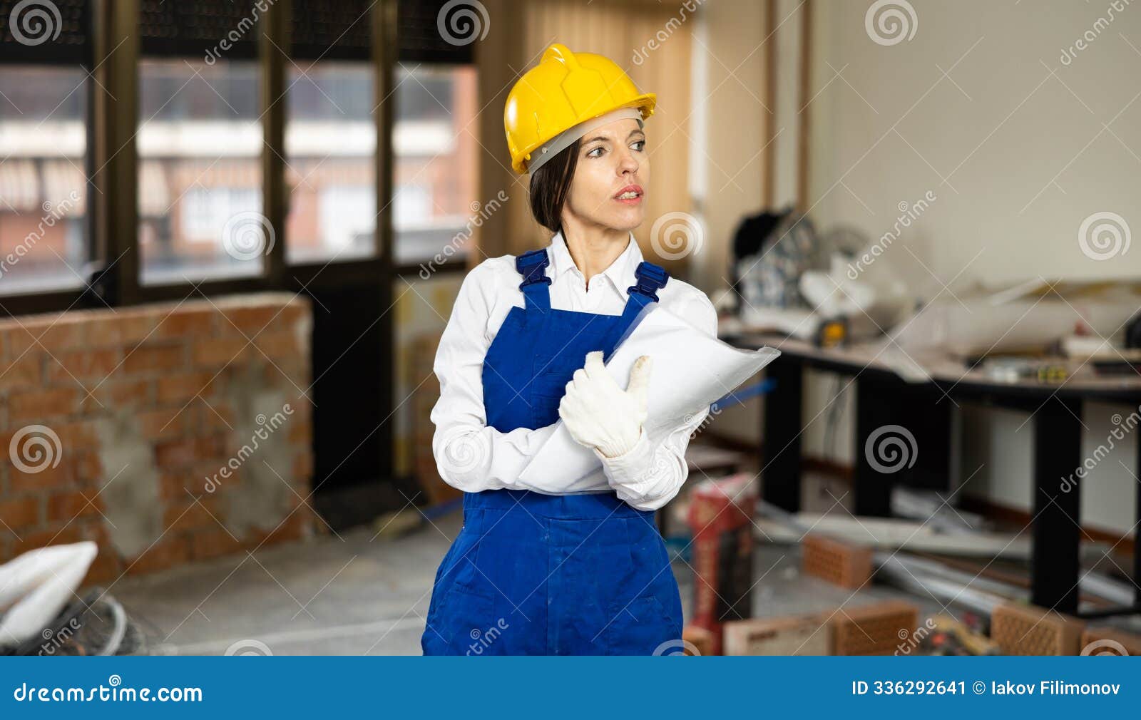 Positive Female Civil Engineer Taking Notes while Checking Indoor ...
