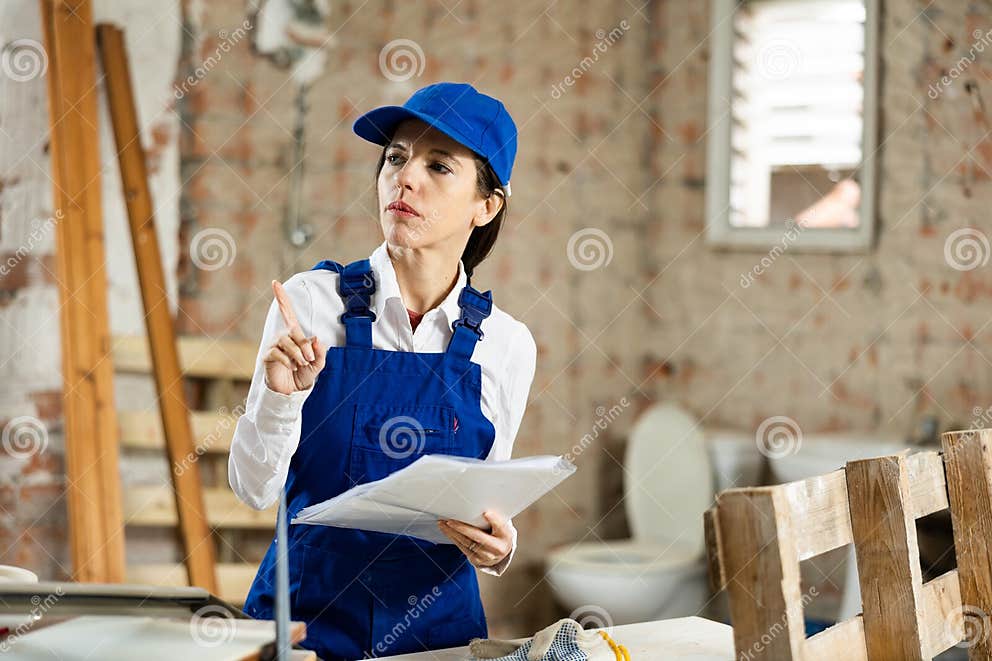 Positive Female Civil Engineer Taking Notes while Checking Indoor ...