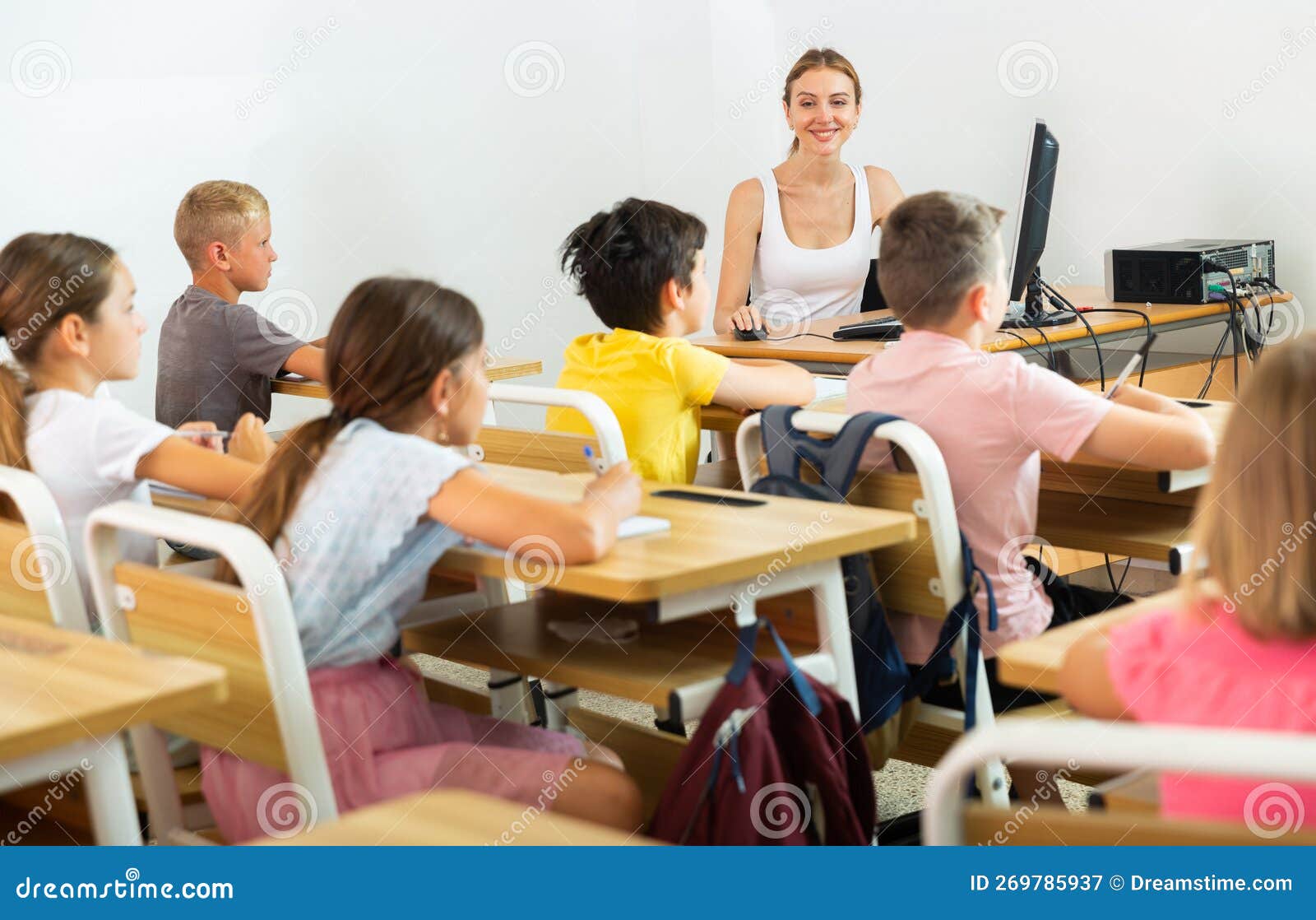 Positive Female Teacher Giving Lesson For Primary School Pupils Stock