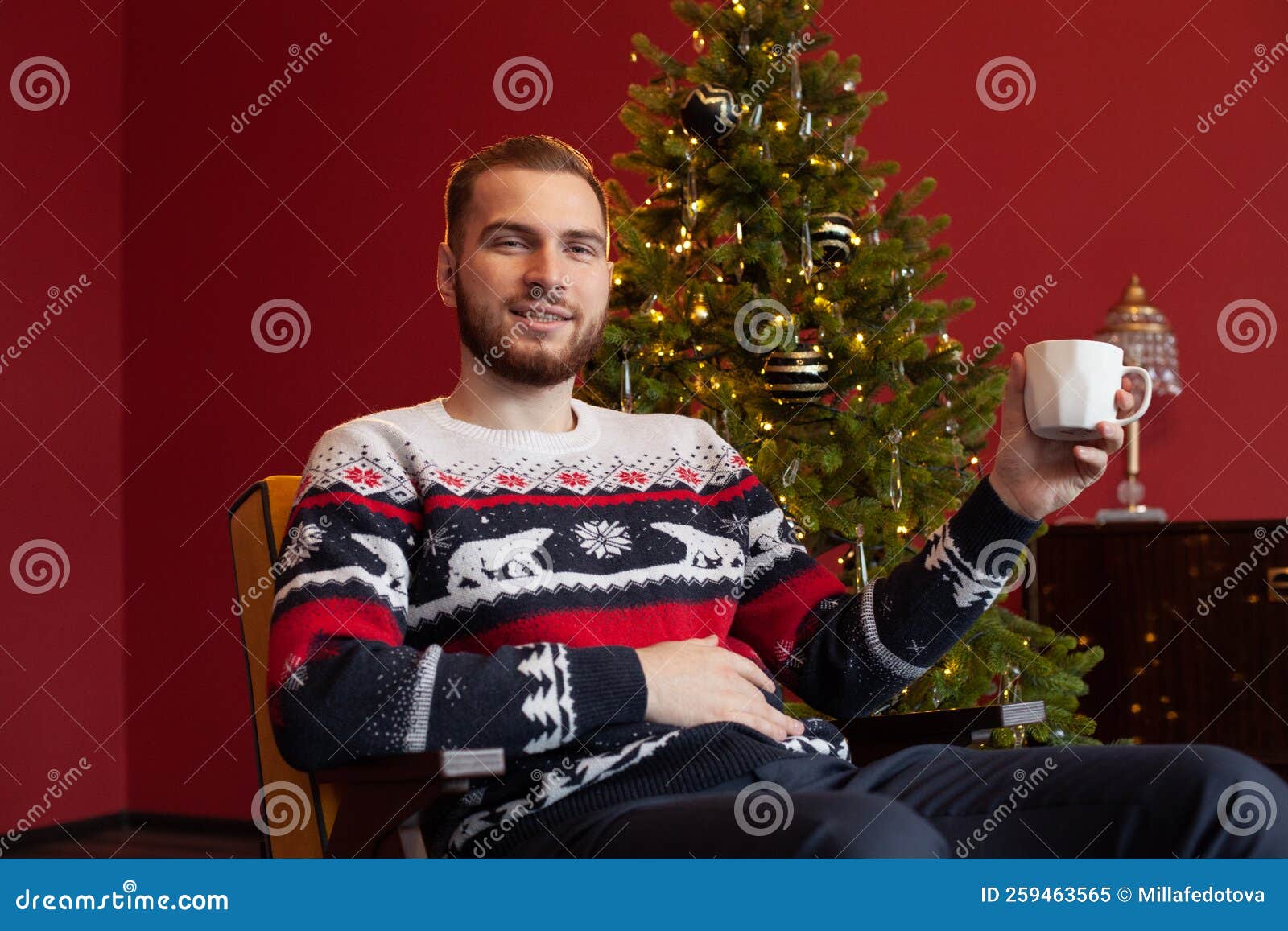 Positive Handsome Man Smiling Holding Cup of Drink Near the Christmas ... Positive Handsome Man Smiling Holding Cup of Drink Near the Christmas ...