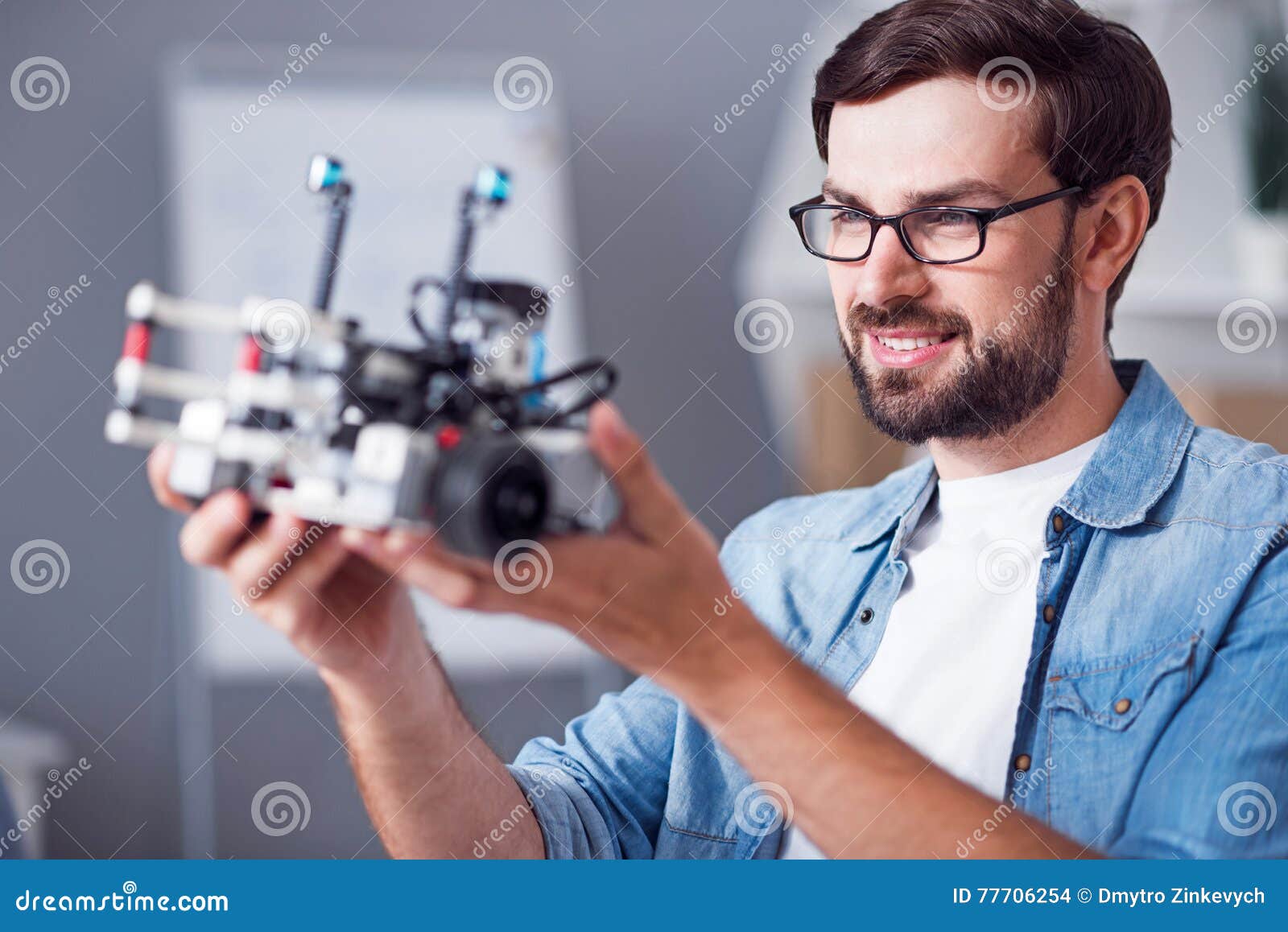 Positive man holding robot stock photo. Image of professional - 77706254