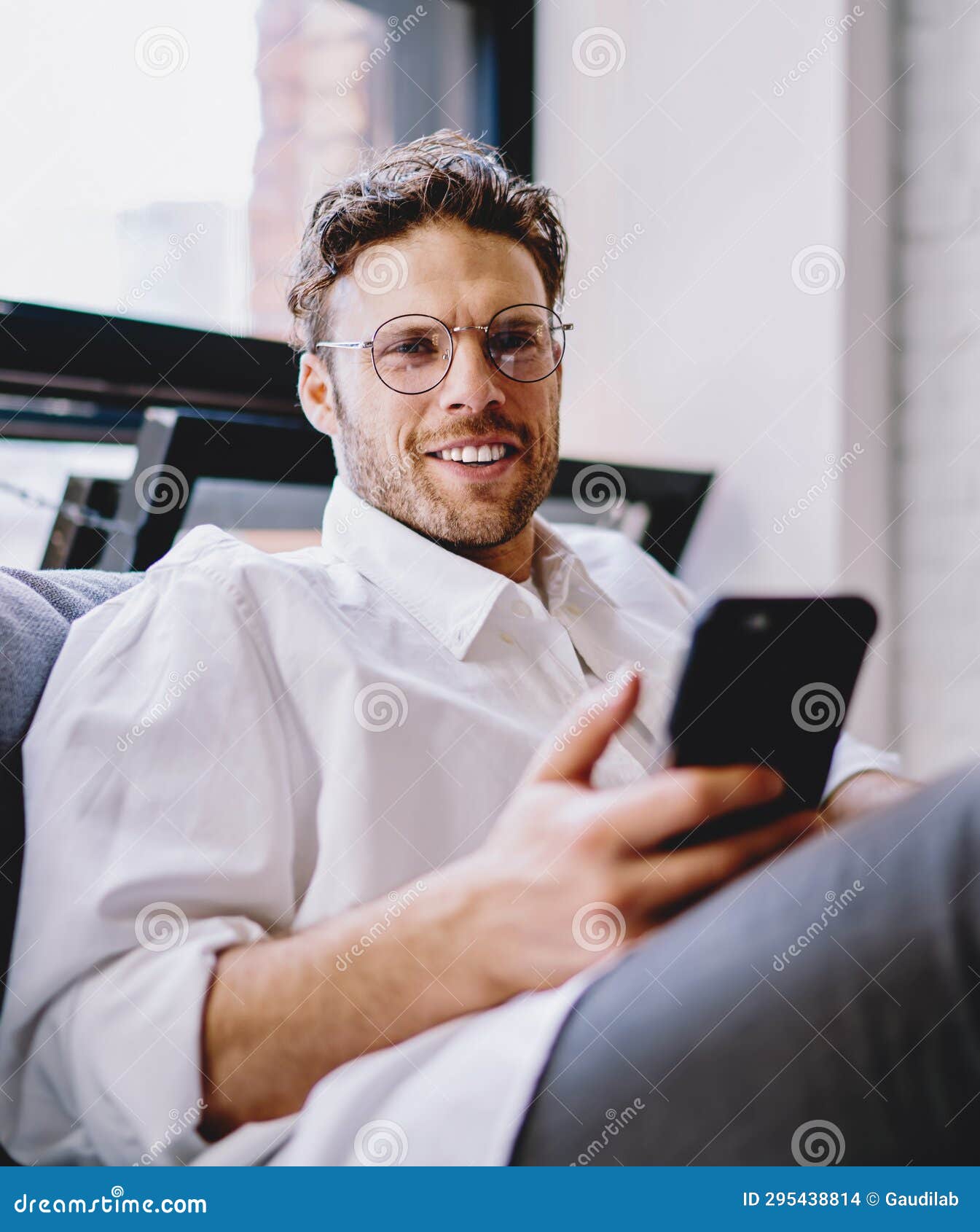 Positive Man Smiling and Holding Smartphone Gadget Stock Photo - Image ...