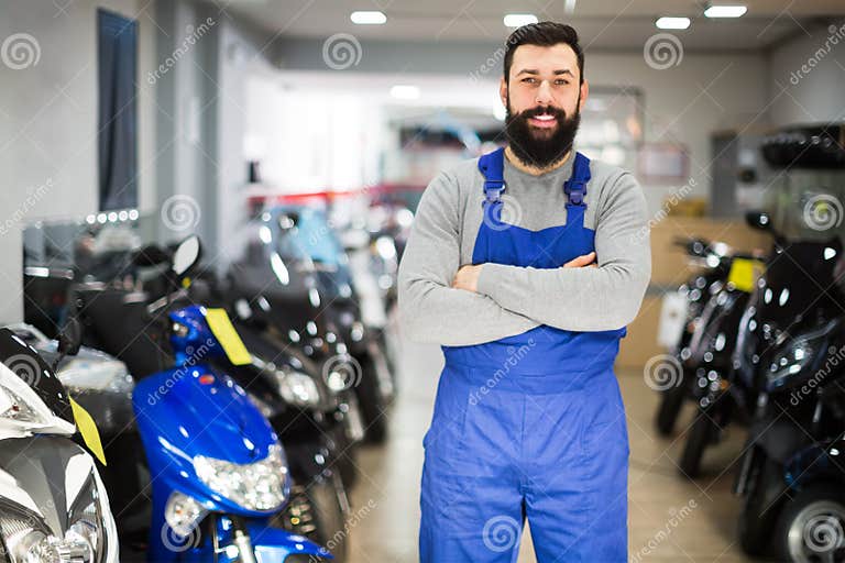 Positive Man Worker Displaying Various Motorcycles in Workshop Stock ...