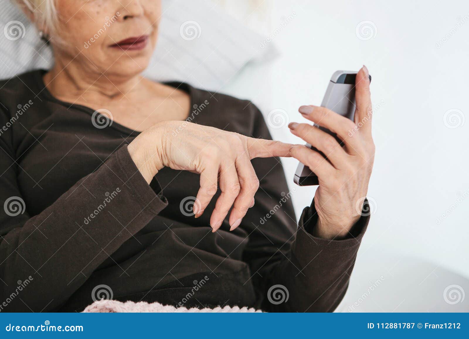 A Positive Modern Elderly Woman is Holding a Cell Phone and is Using it ...