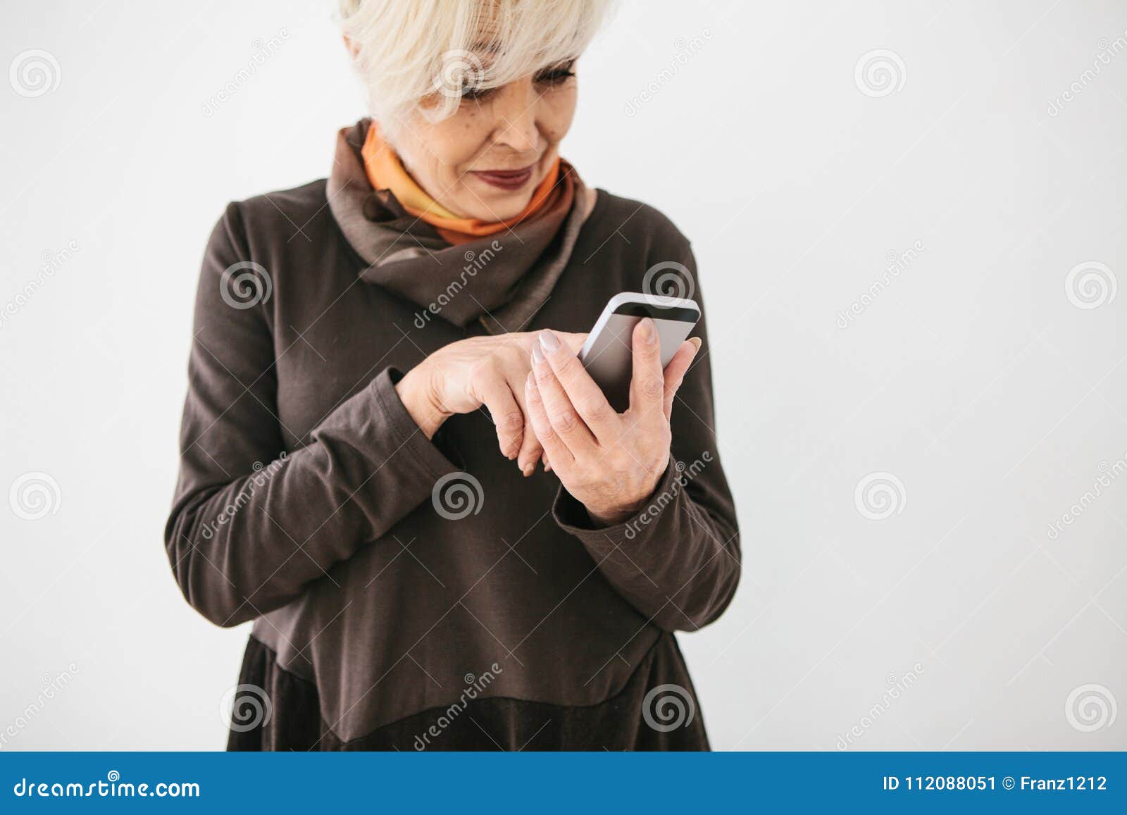 A Positive Modern Elderly Woman is Holding a Cell Phone and is Using it ...