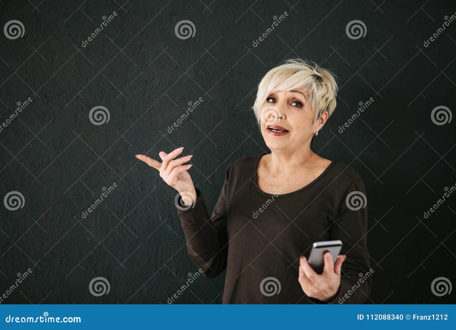 A Positive Modern Elderly Woman is Holding a Cell Phone and is Using it ...