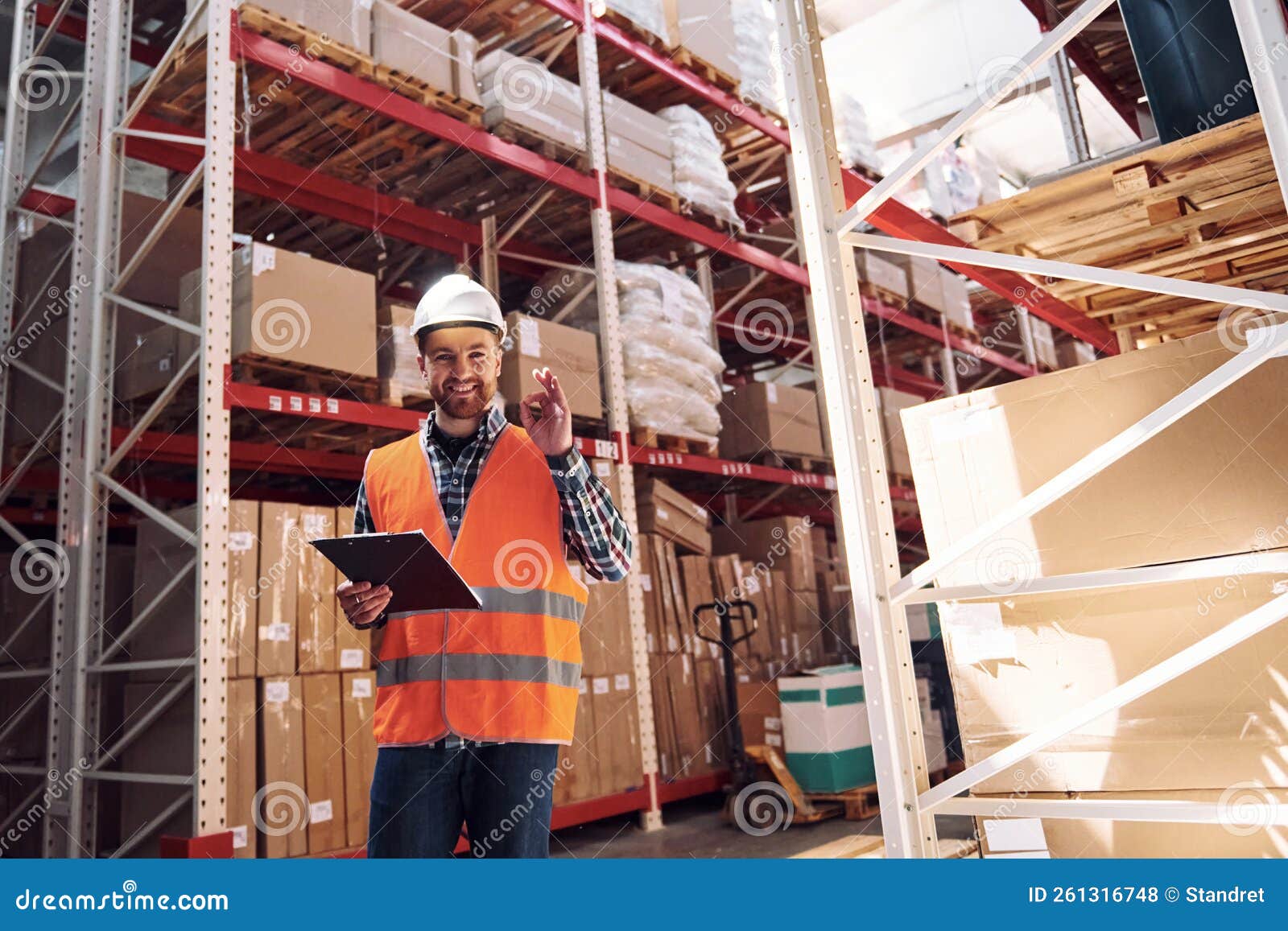 Positive Mood. Employee in Uniform is Working in the Storage at Daytime ...