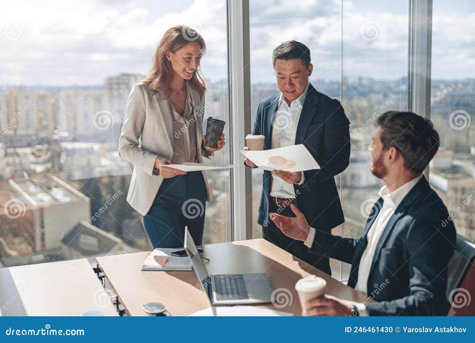 Positive Office Employees Discussing Work Issues Using Laptop and ...