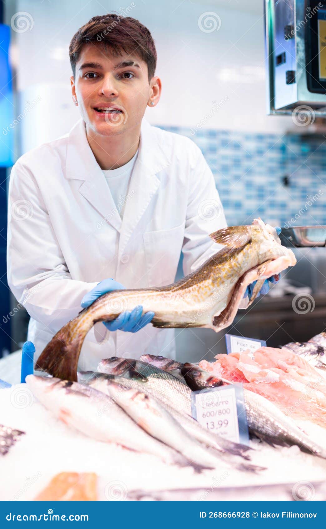 Positive Salesman Demonstrating Cod in Fish Store Stock Photo - Image ...