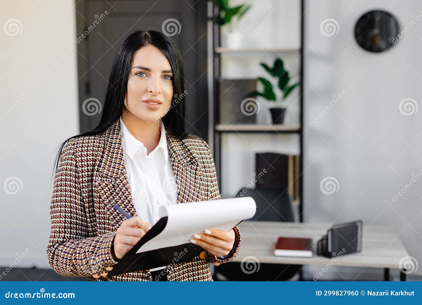 Positive Woman Sitting at Office Table Writing Notes on Paper while ...